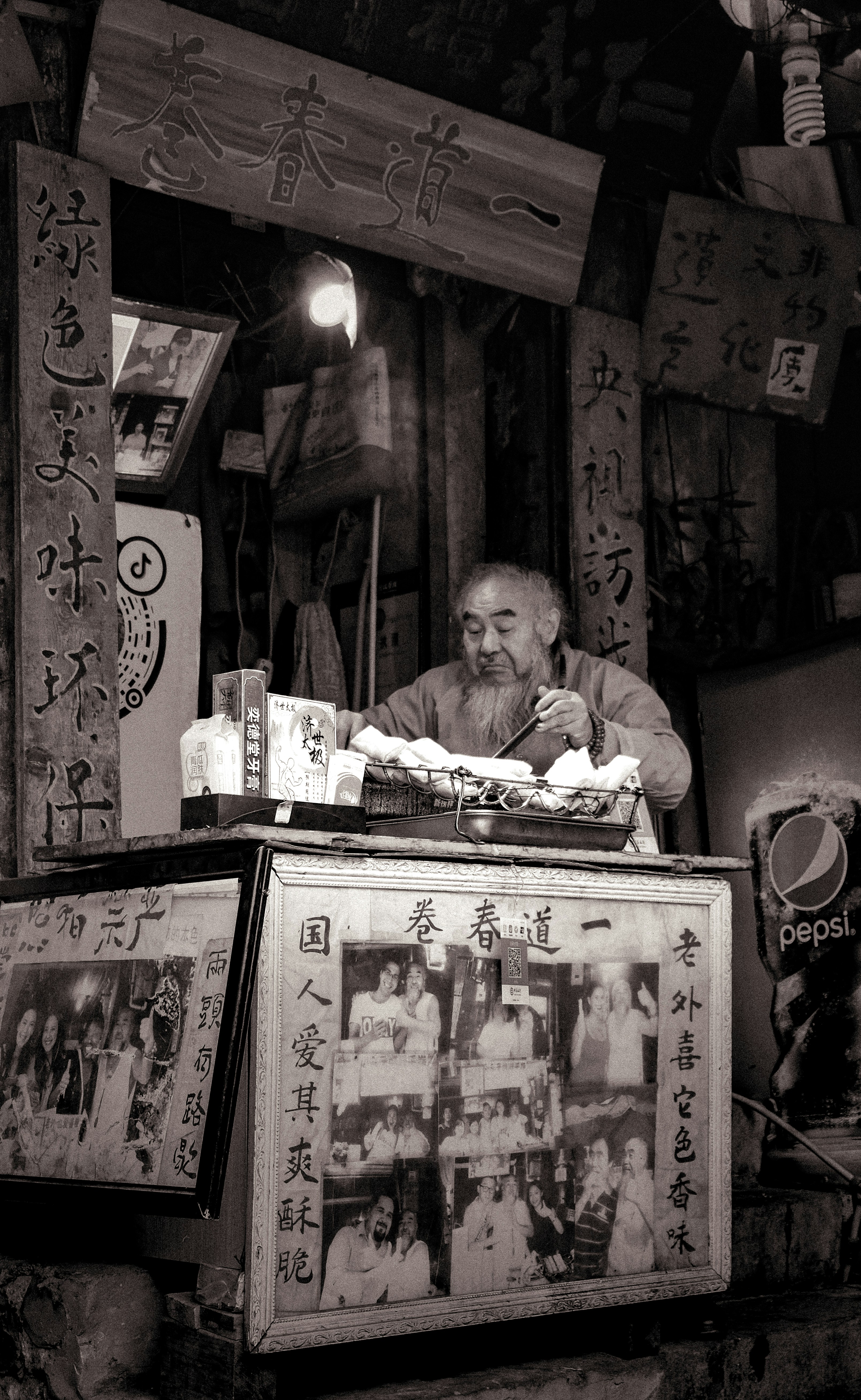 Monochrome Stall Portrait: An Elder Vendor Under Calligraphic Signs