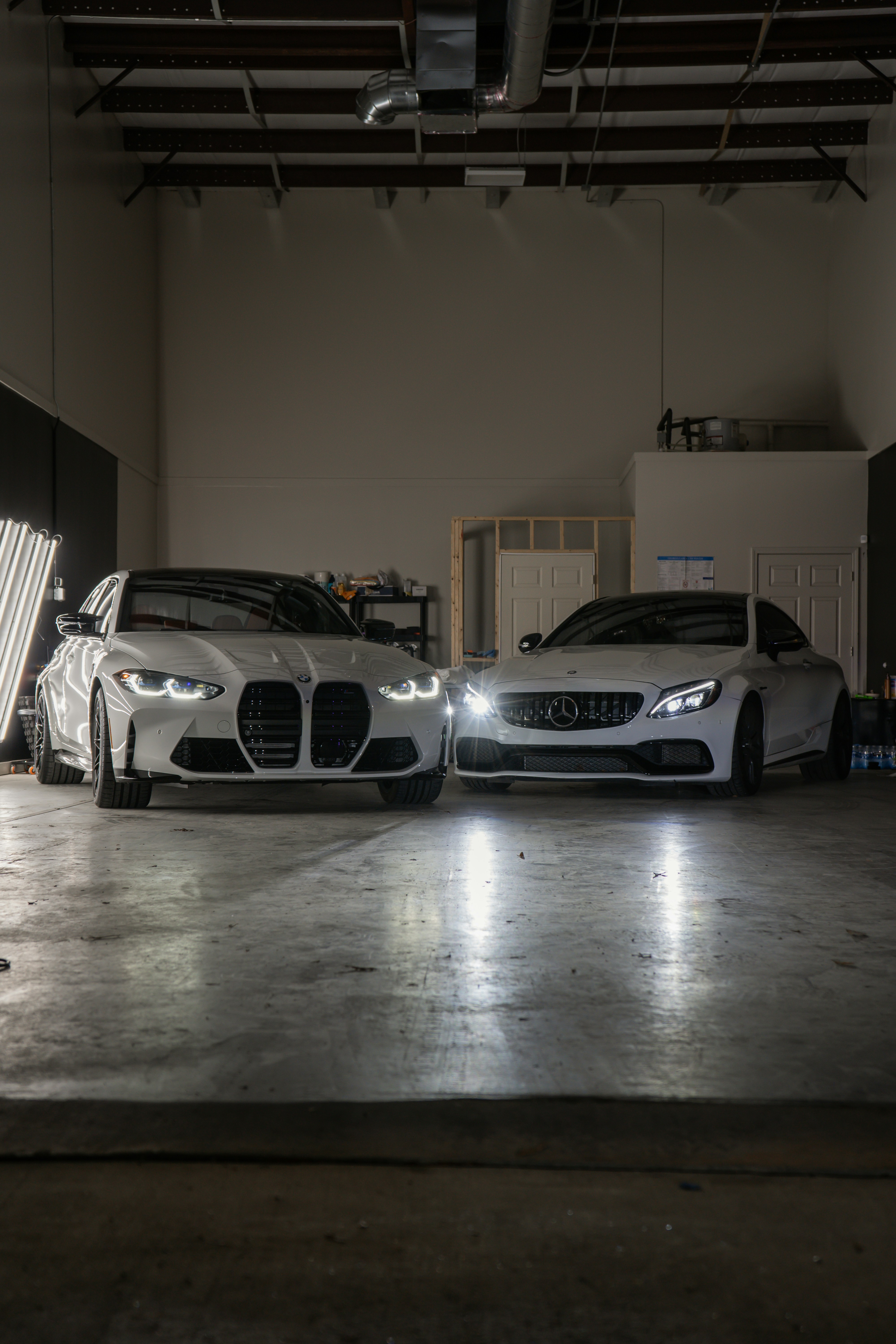 Two white cars parked in a garage next to each other photo – Free ...