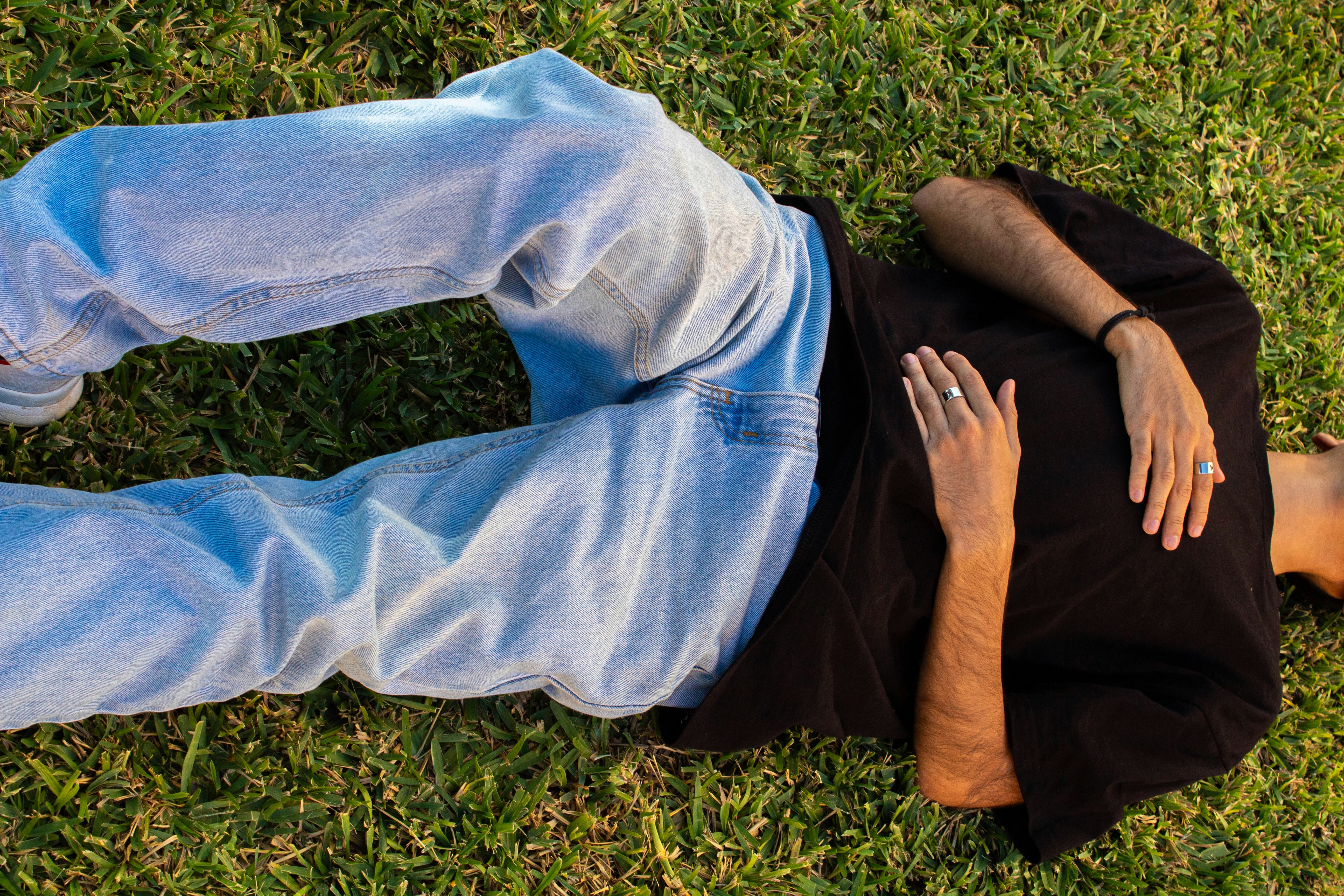 A man laying in the grass with his hands on his chest photo – Free Man ...