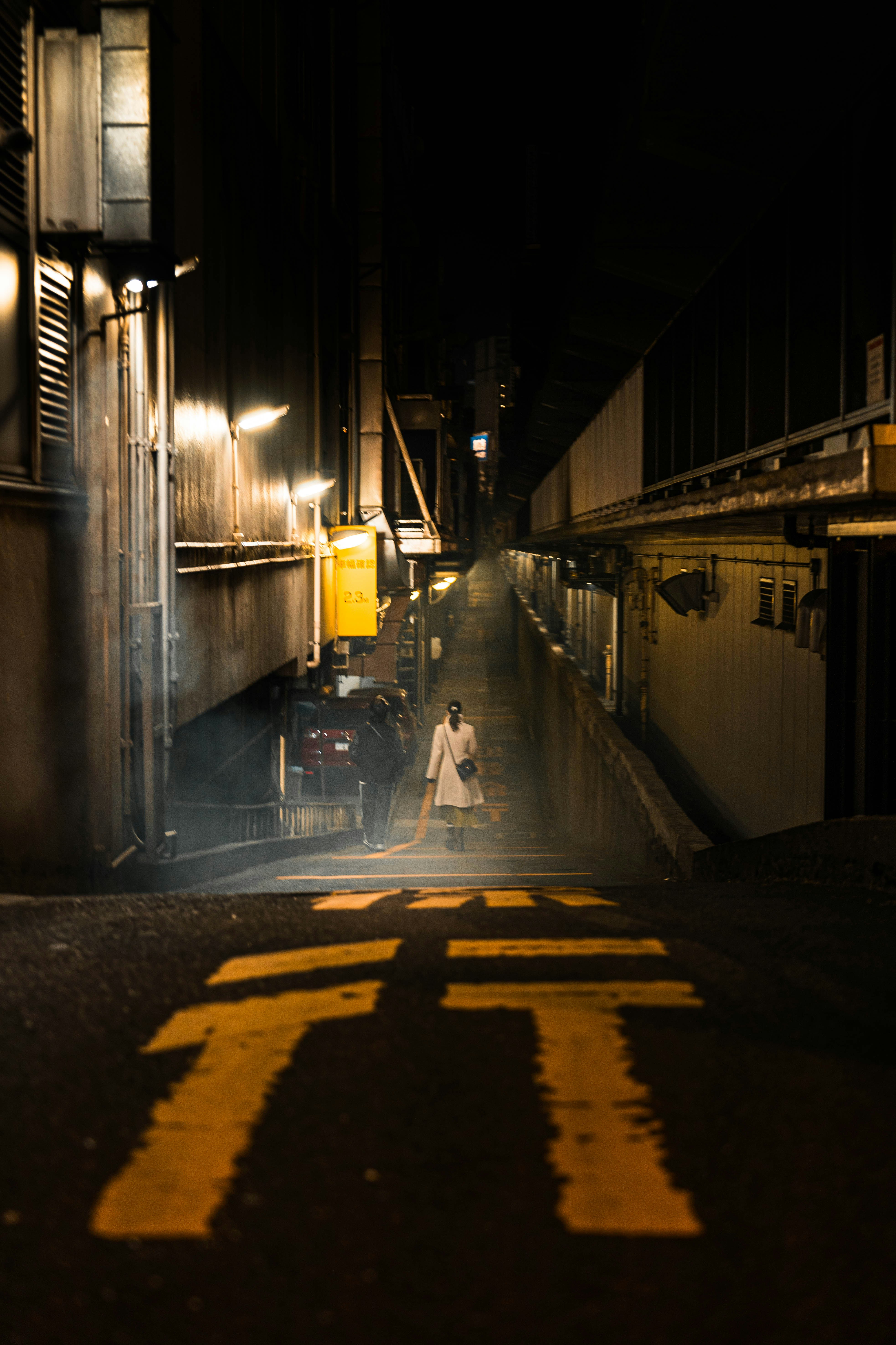 Solitary Figure under Urban Lanterns in a Narrow Night Alley