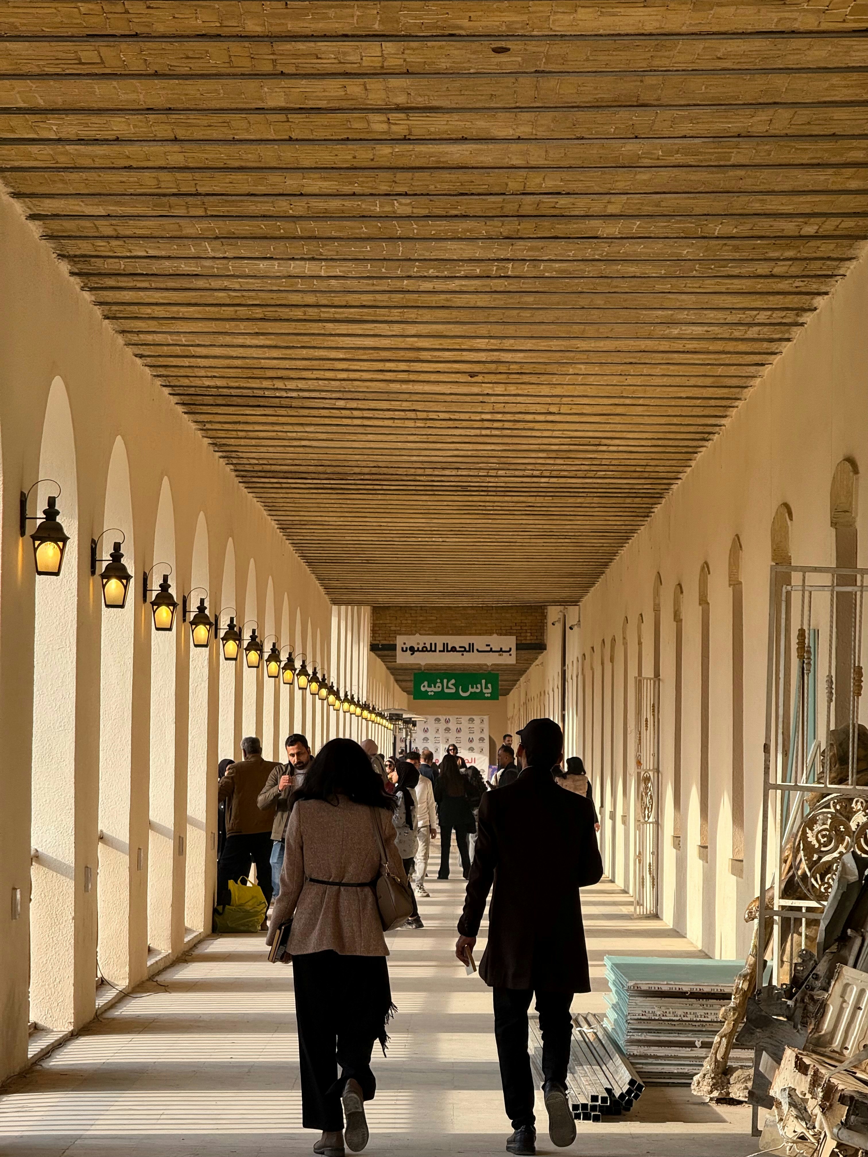 Lantern-lit Archway Corridor Leading to a Green Market Sign