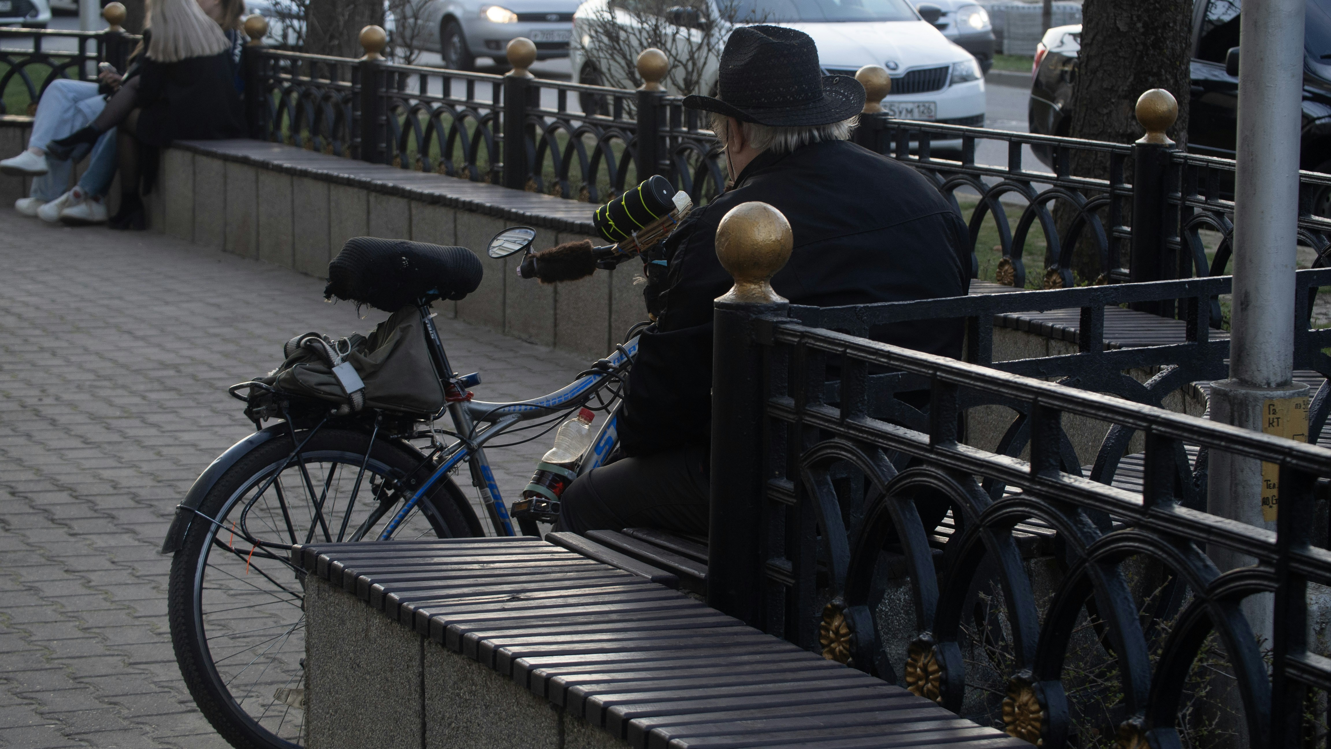 Shadowed Observer by the Railing, Beside a Bicycle