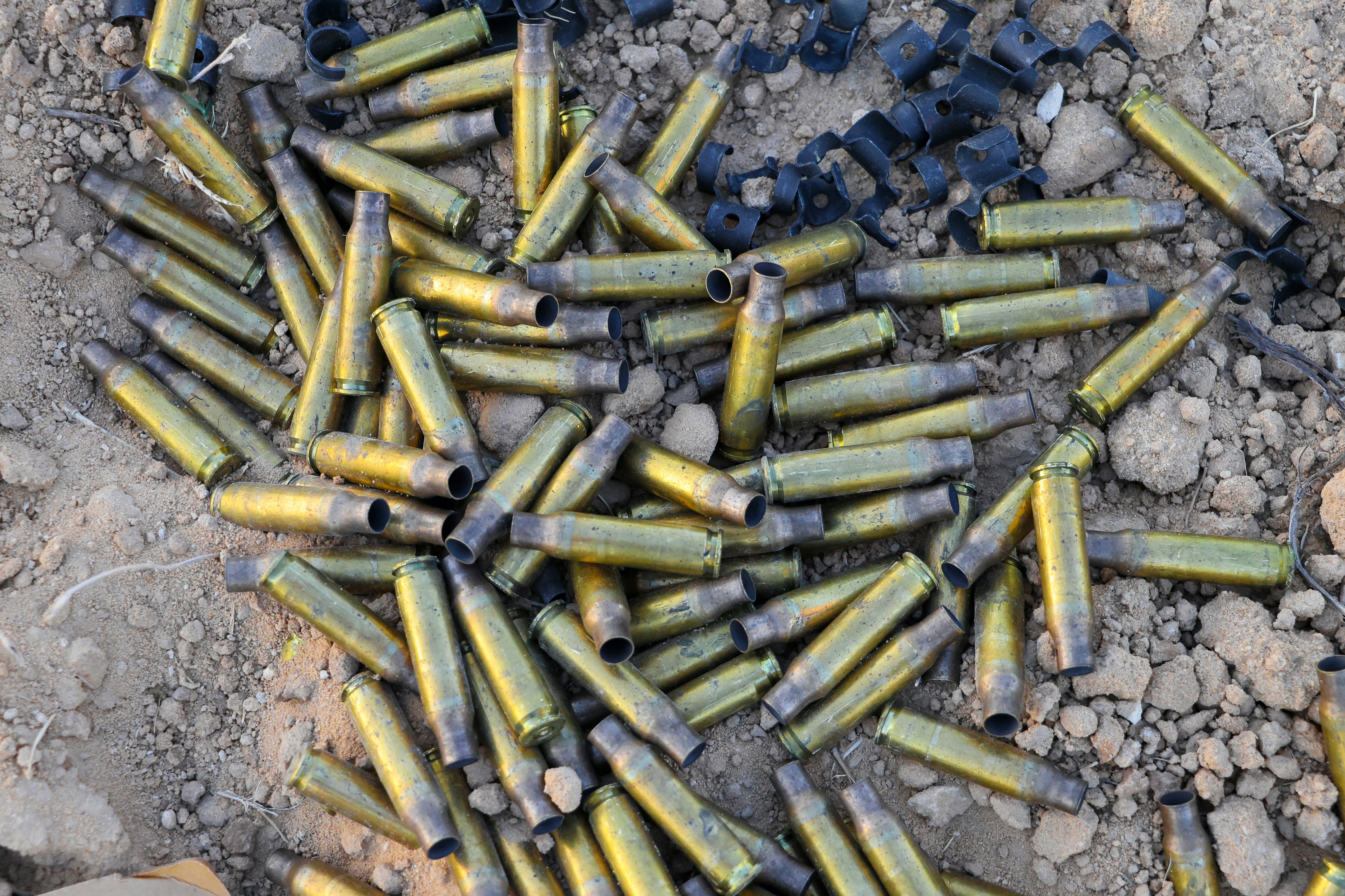 A bunch of bullet shells laying on the ground photo – Free Weapon Image ...
