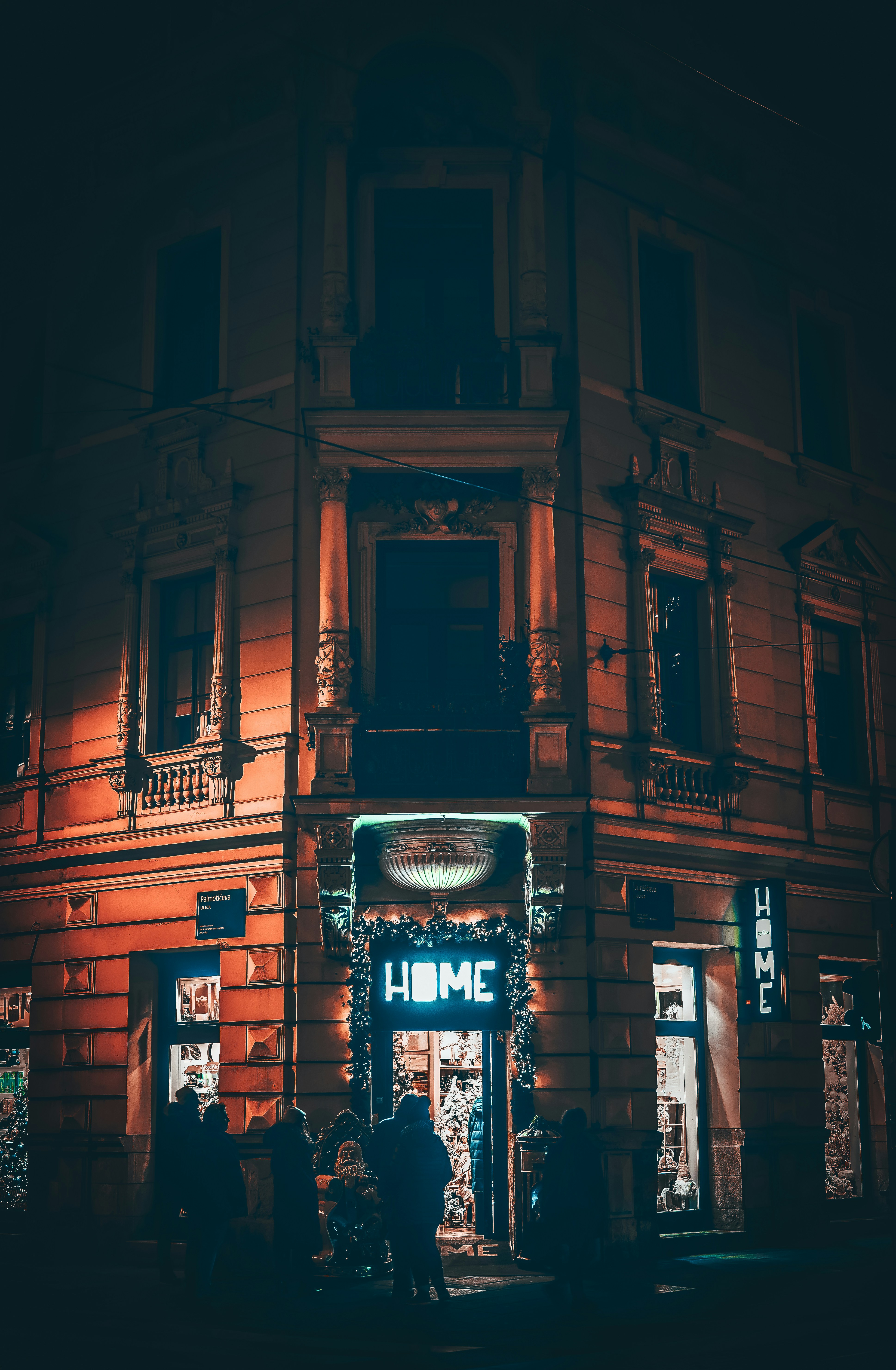 A group of people standing outside of a building at night photo – Free ...