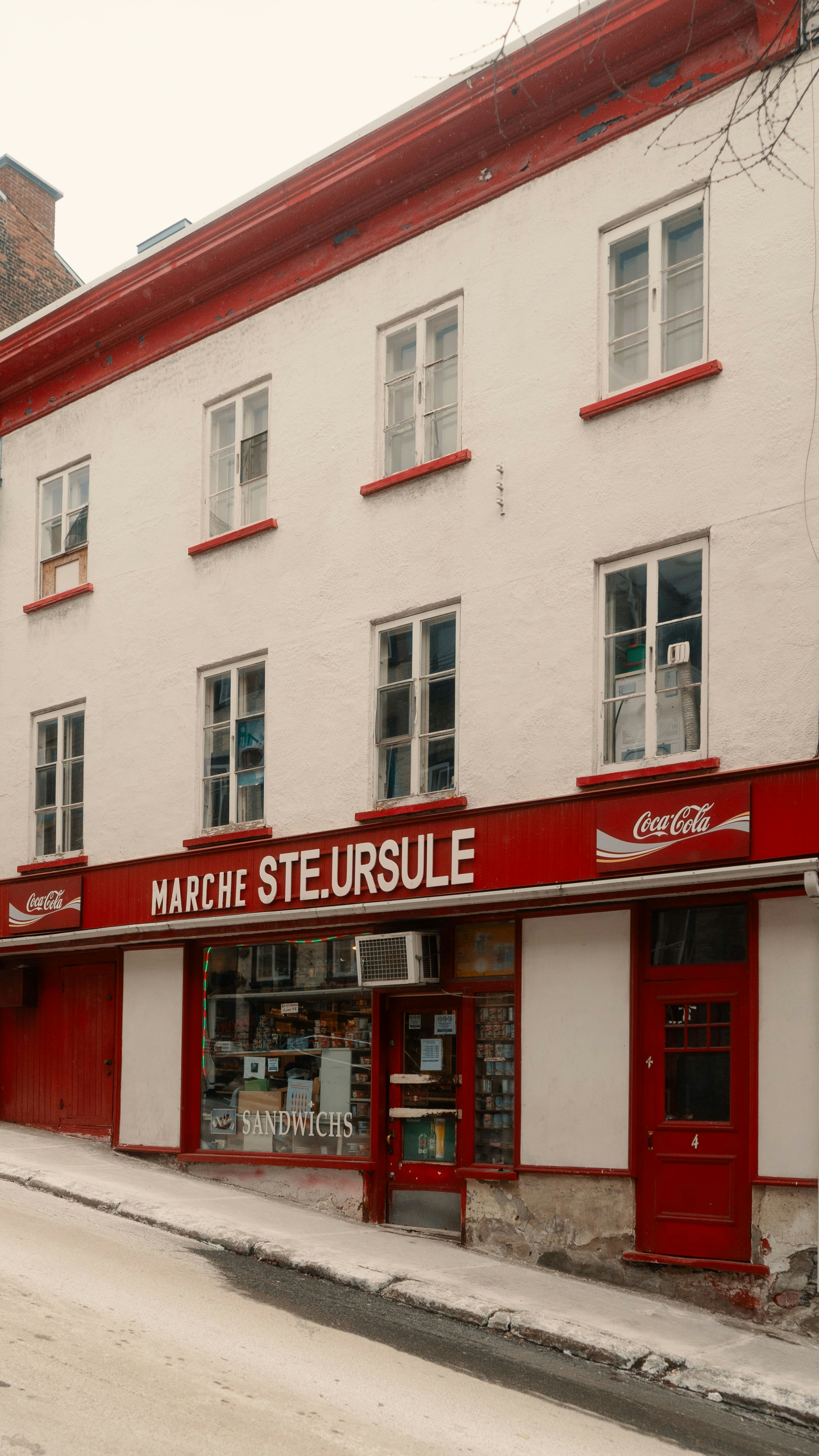 A red and white building sitting on the side of a road photo – Free ...