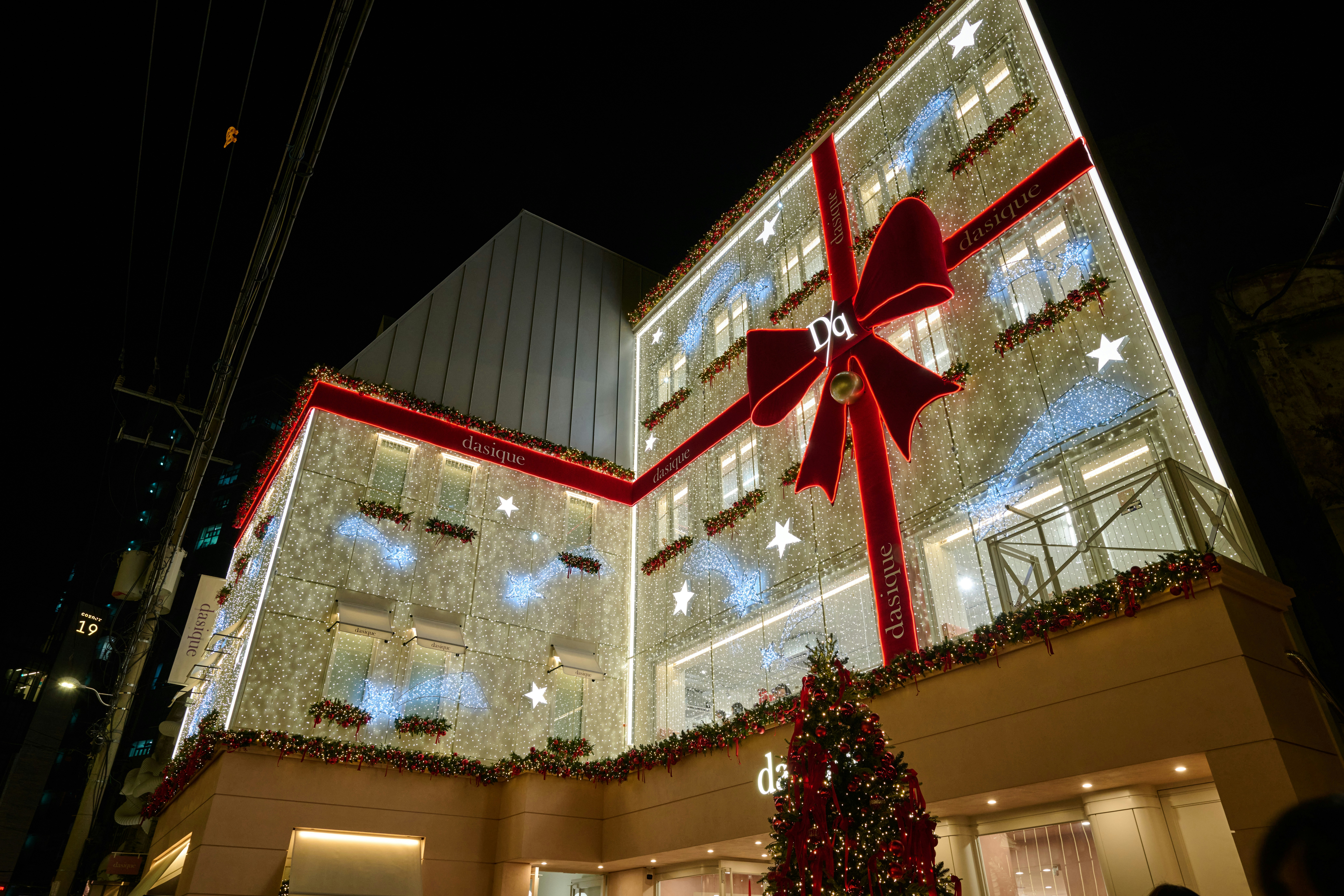 The Grand Christmas Bow: Pearl-Lit Facade Framed by a Giant Red Ribbon
