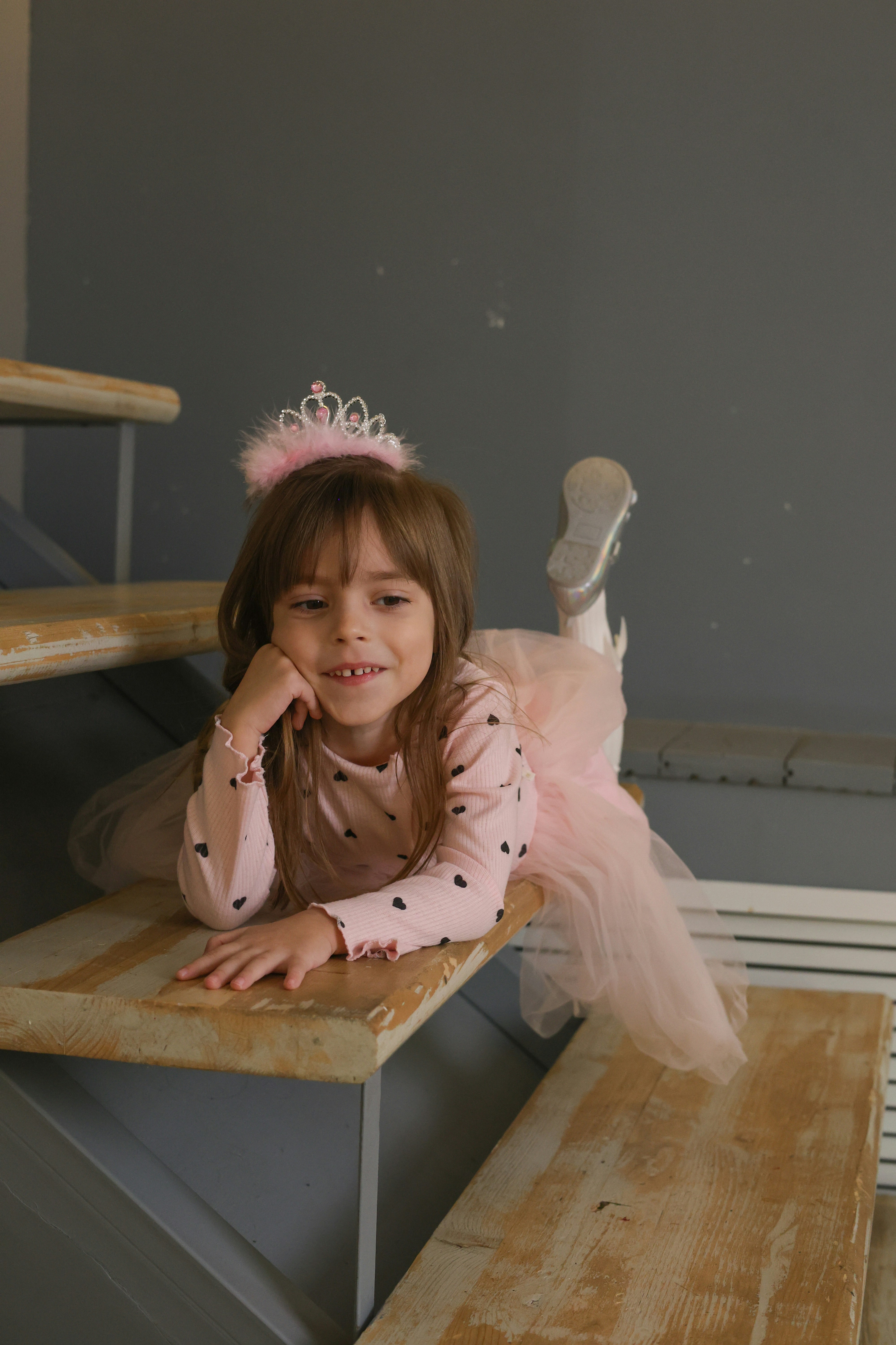 A little girl sitting on a wooden bench wearing a tiara photo – Free ...
