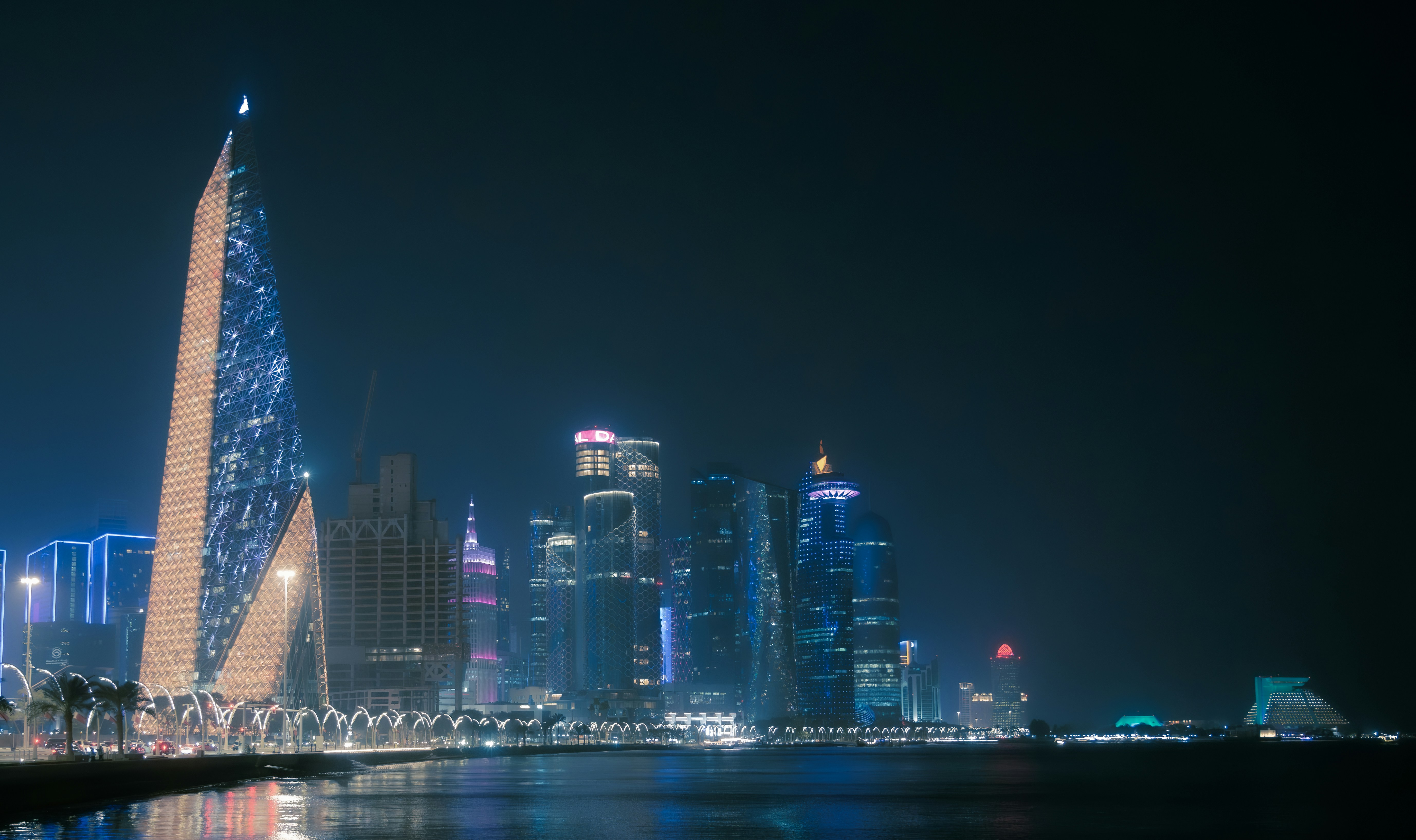 Neon Triangle and Glass Towers: Nighttime Waterfront Skyline