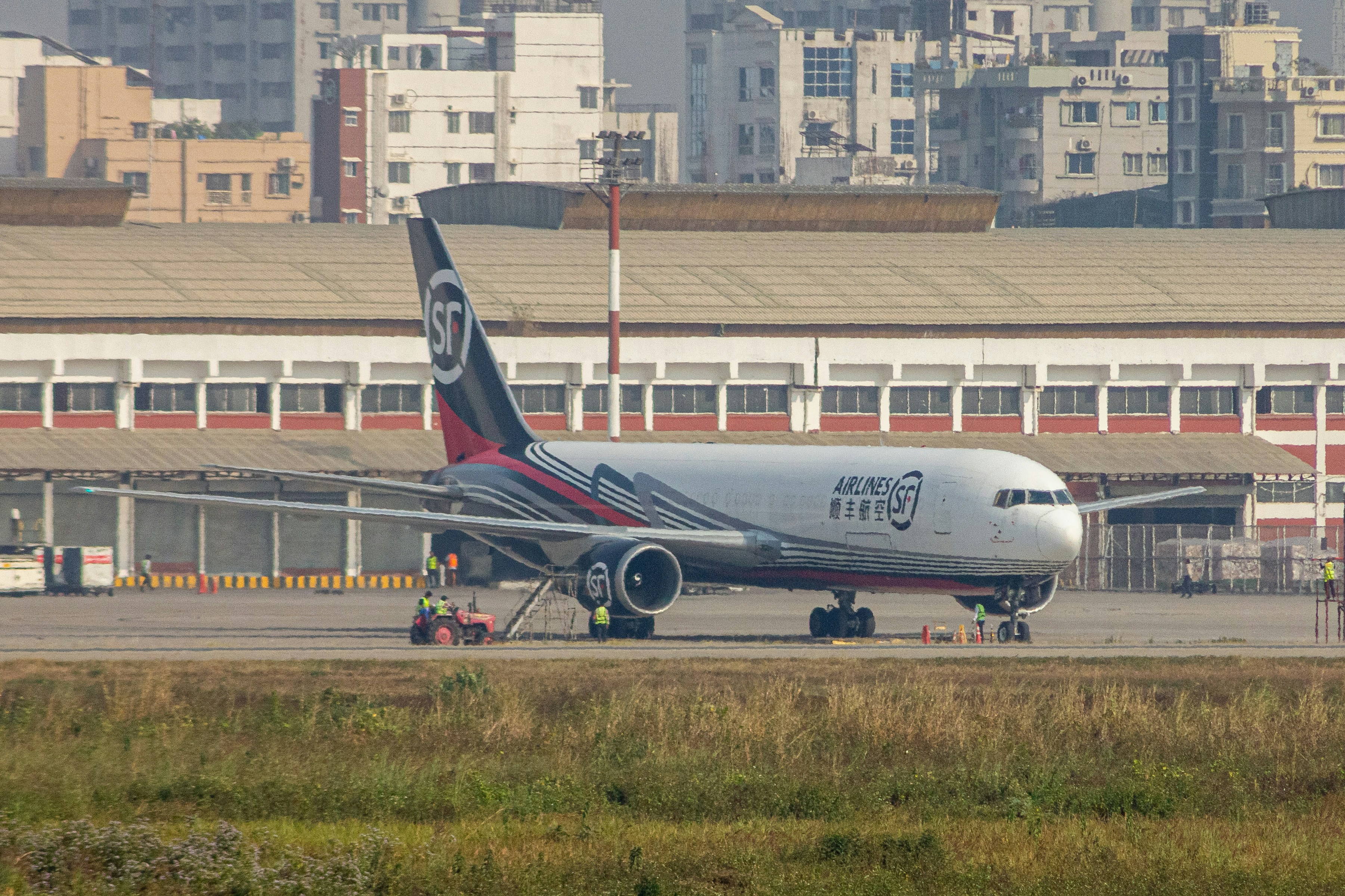 Apron Idle: An SC-livery widebody with a distant cityscape