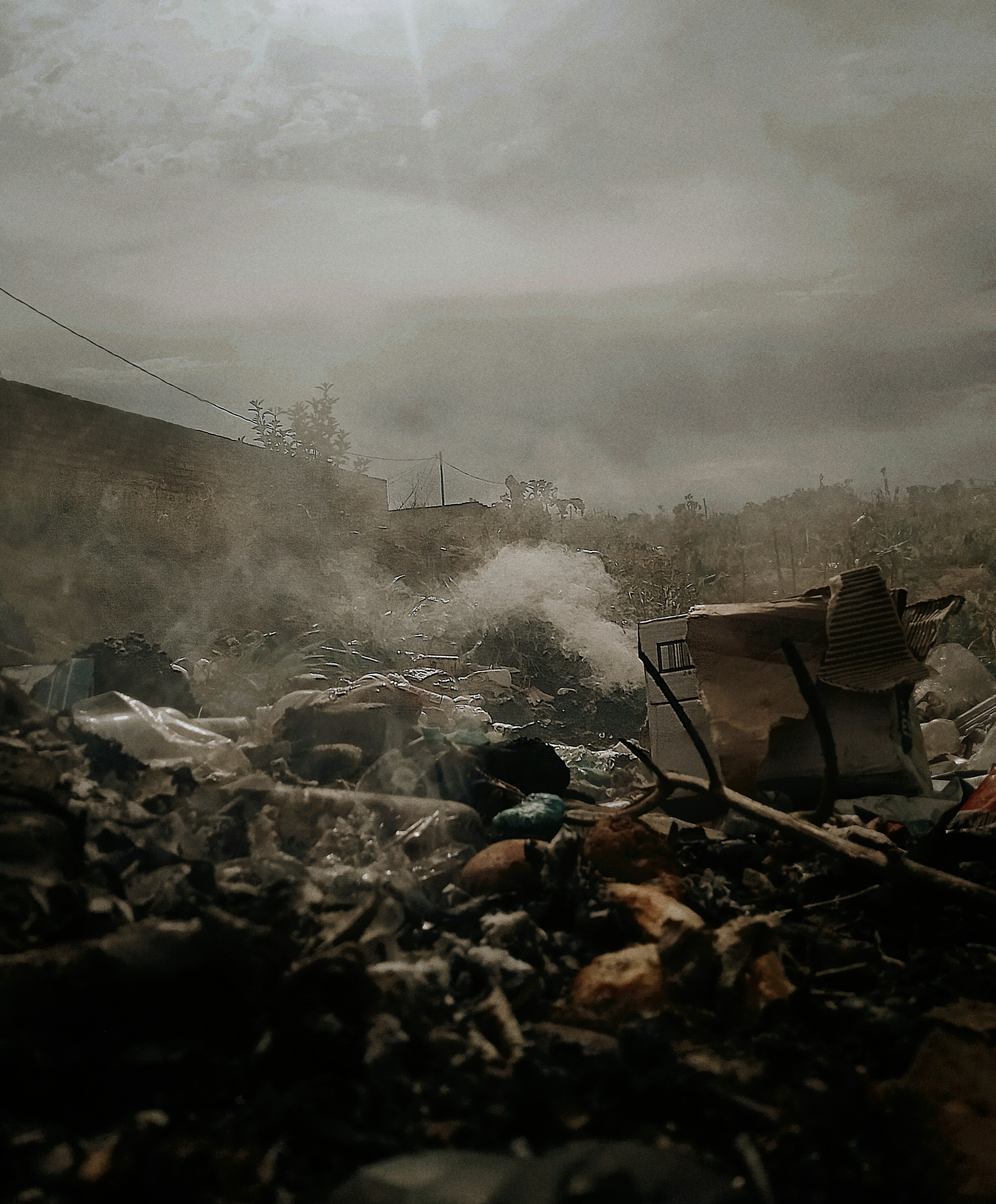 A pile of trash sitting on top of a dirt field photo – Free Garbage ...