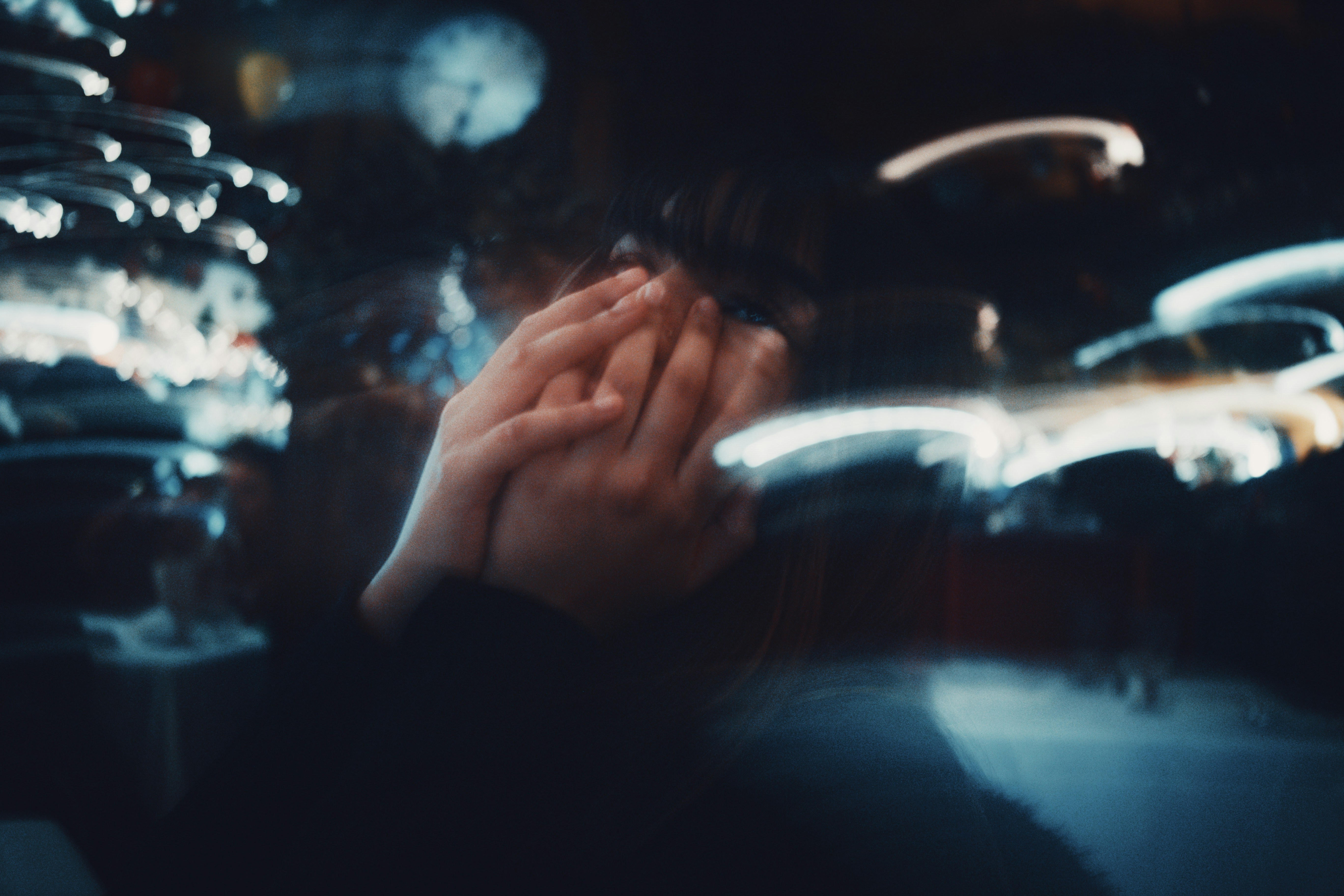Veil of Neon: Hands Shrouded in Urban Light Trails