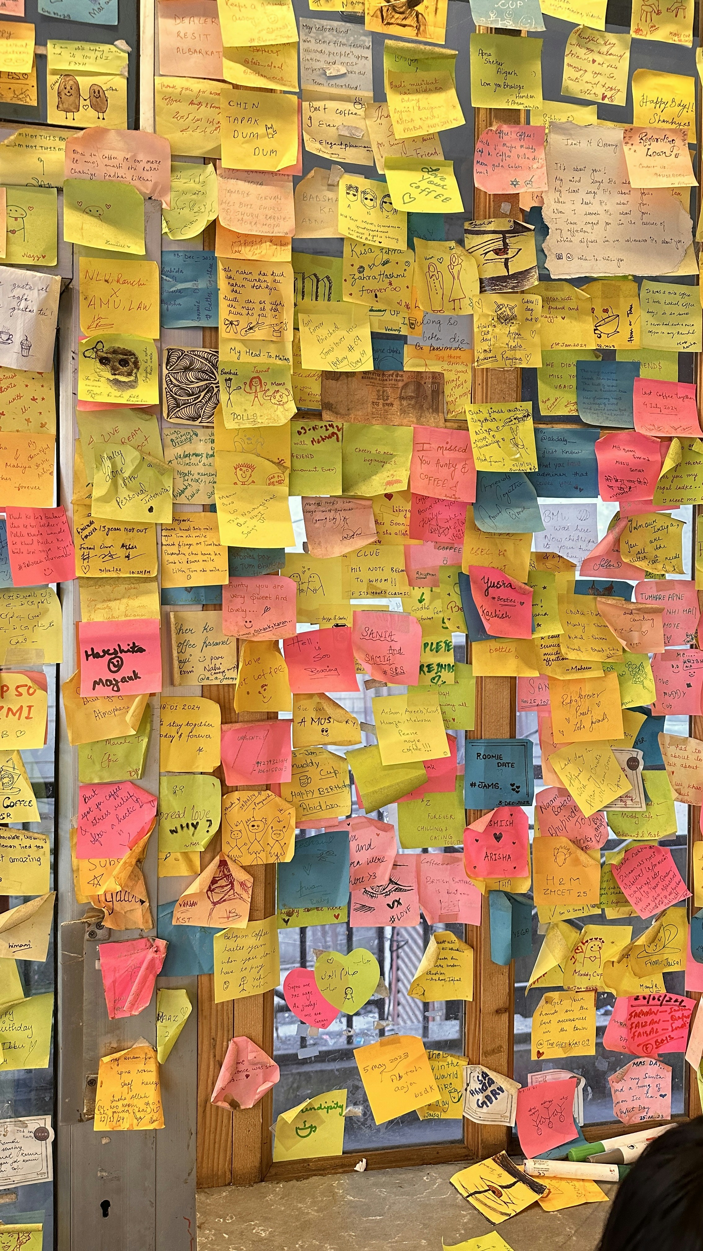 A woman sitting in front of a wall covered in post it notes photo ...