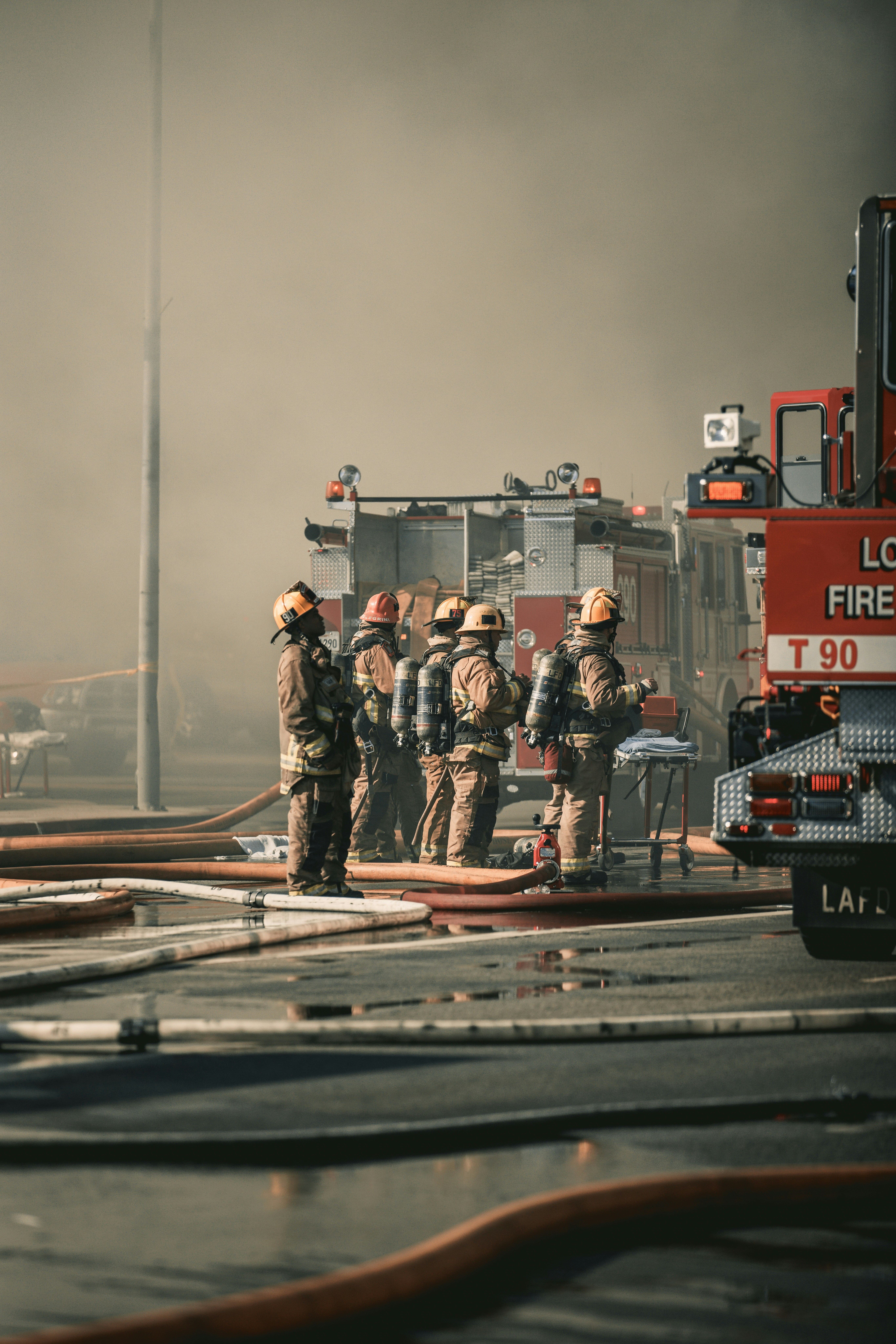 A group of firefighters standing around a fire truck photo – Free ...