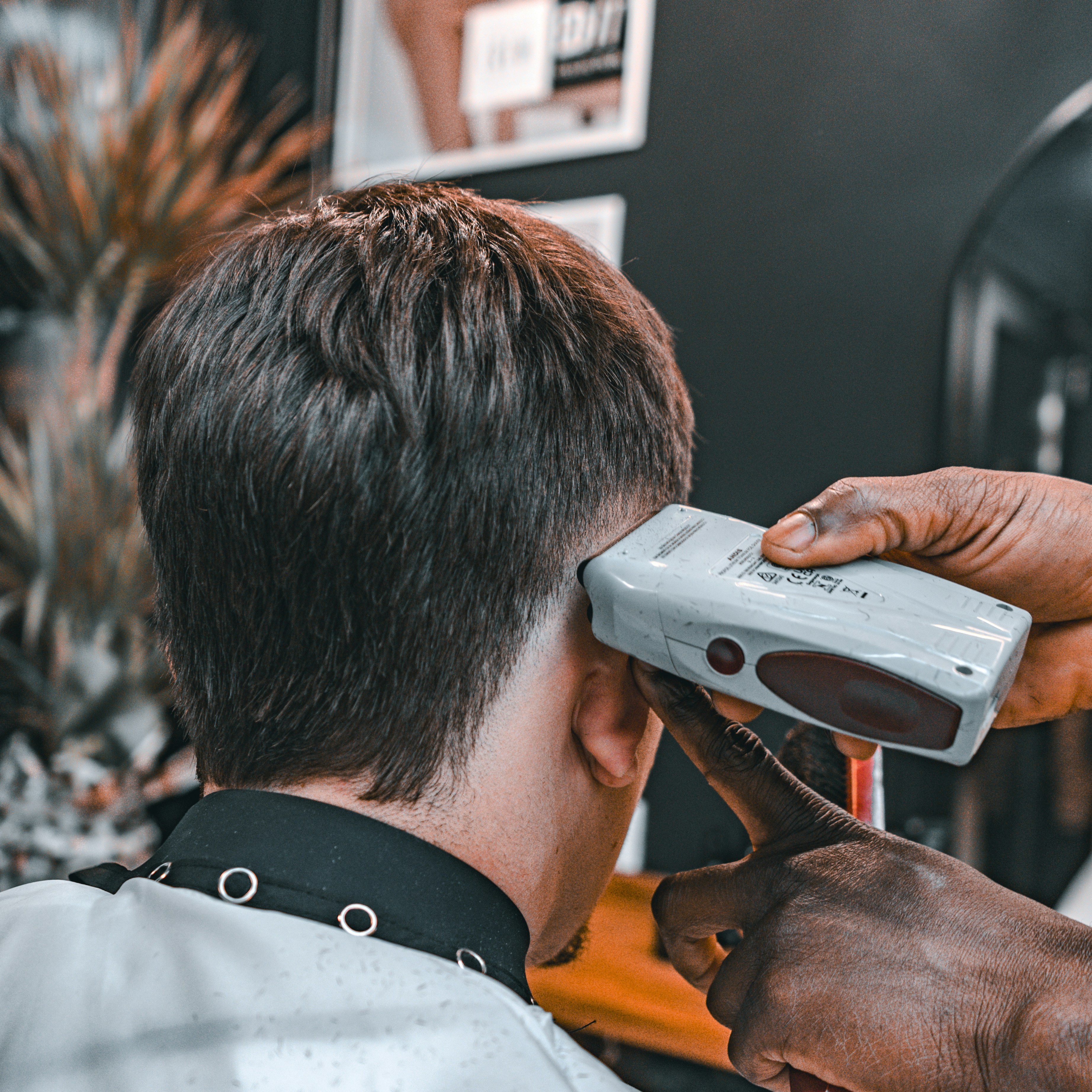 A man getting his hair cut at a barber shop photo – Free Barber Image ...