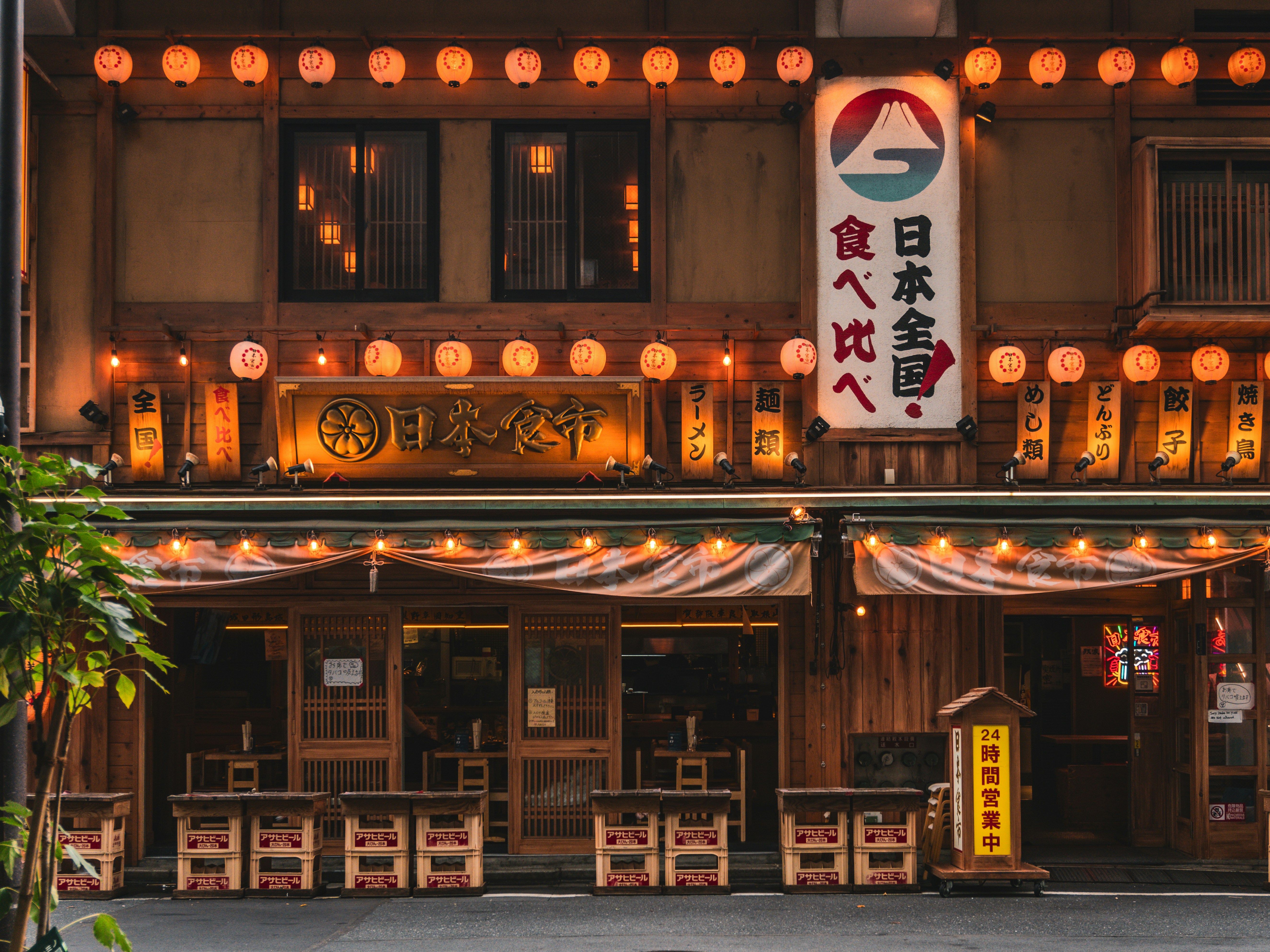 Traditional Japanese izakaya adorned with warm lanterns and wooden accents on a quiet street.