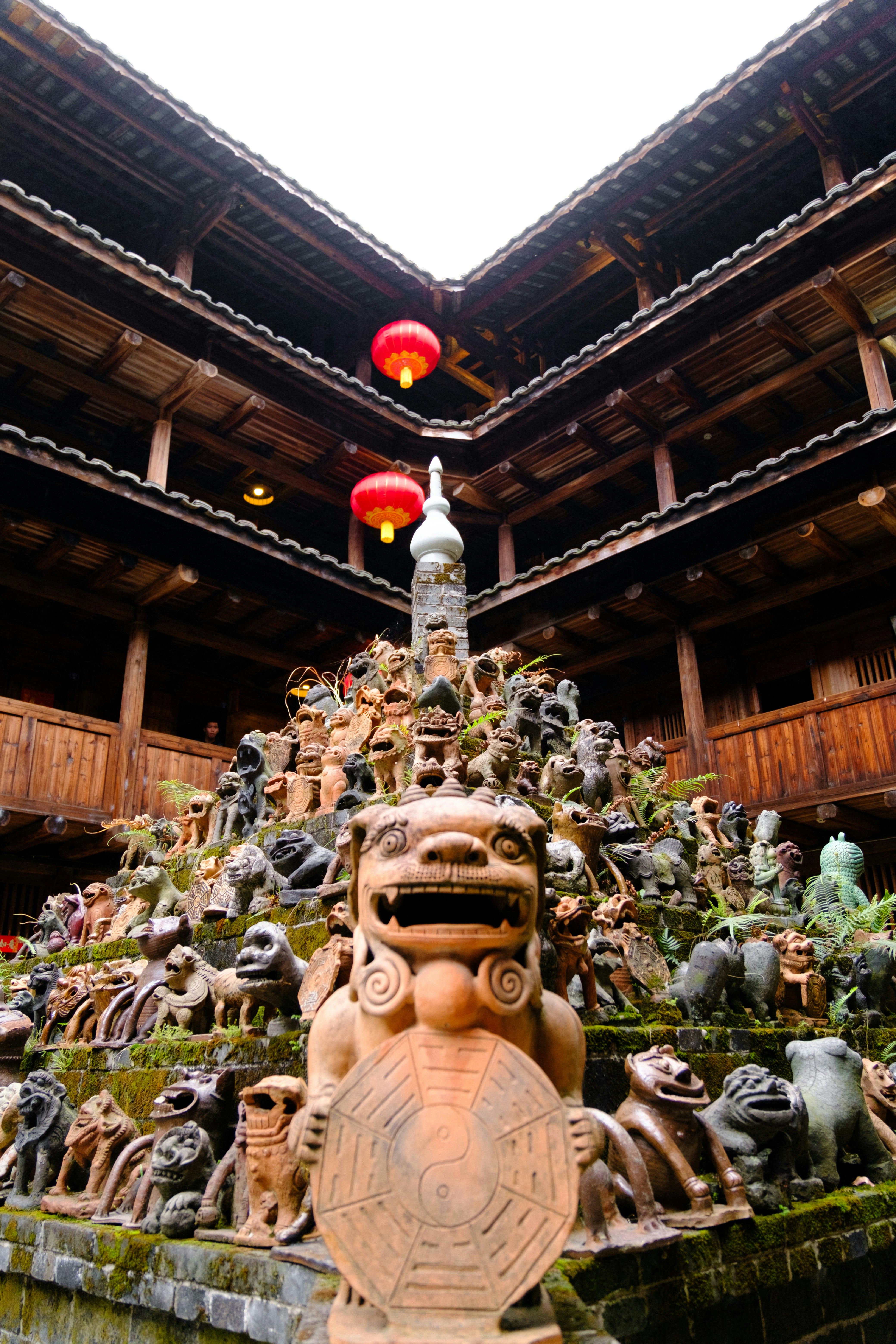 Pyramid of Guardians Under Red Lanterns in a Timbered Courtyard
