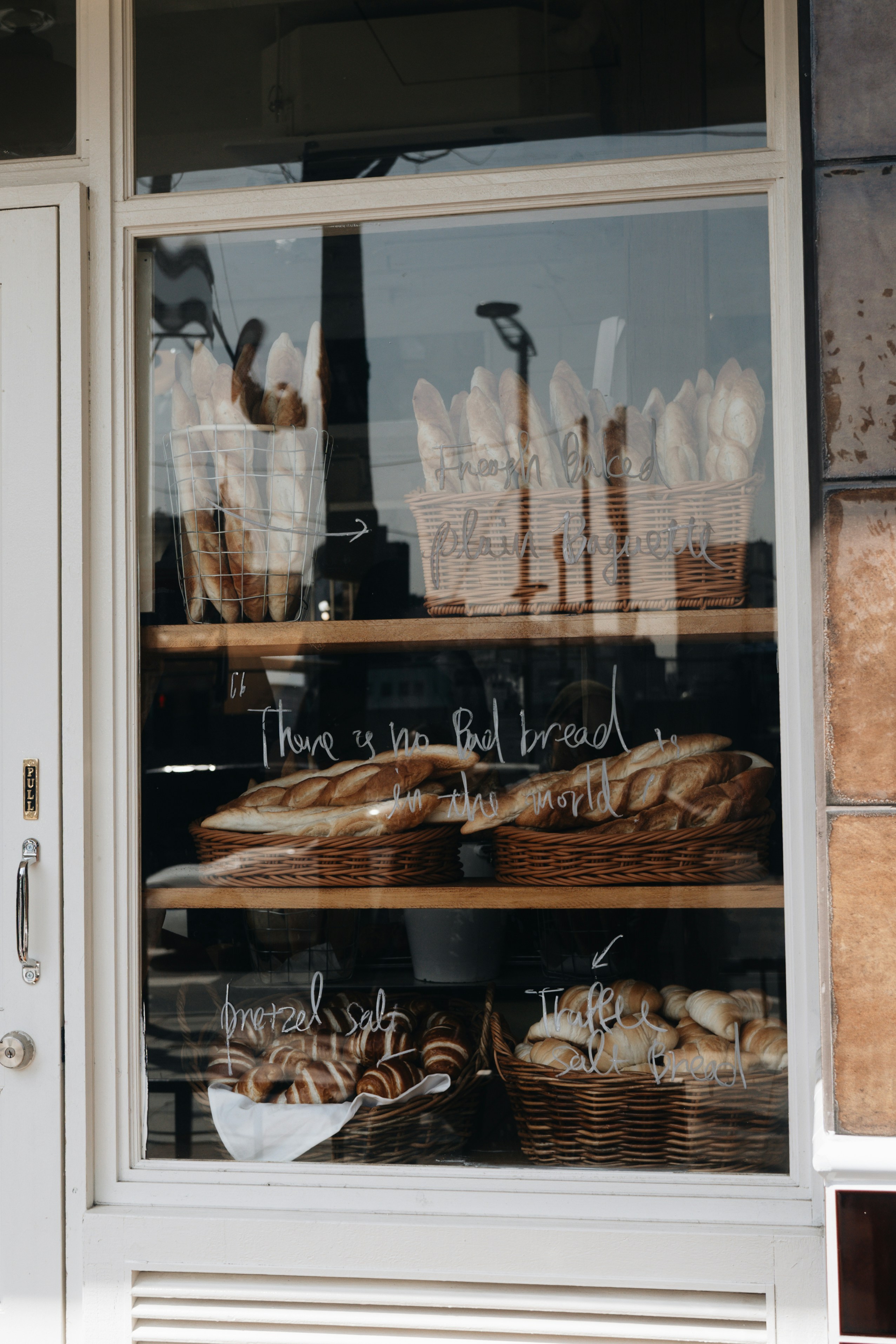 A bakery window with bread and pastries in it photo – Free Furniture ...