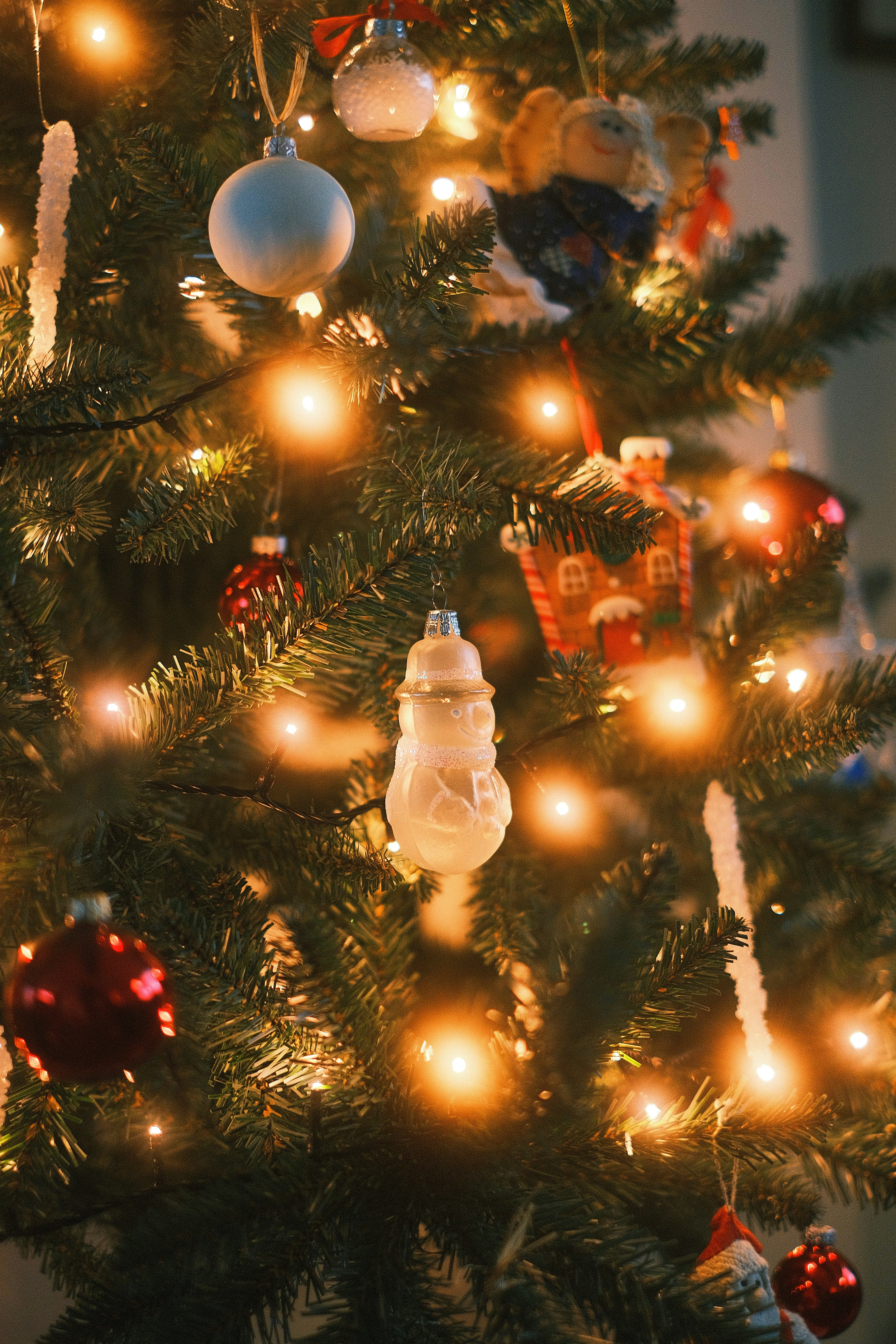 Snowman Ornament Centerstage on a Warmly Lit Christmas Tree