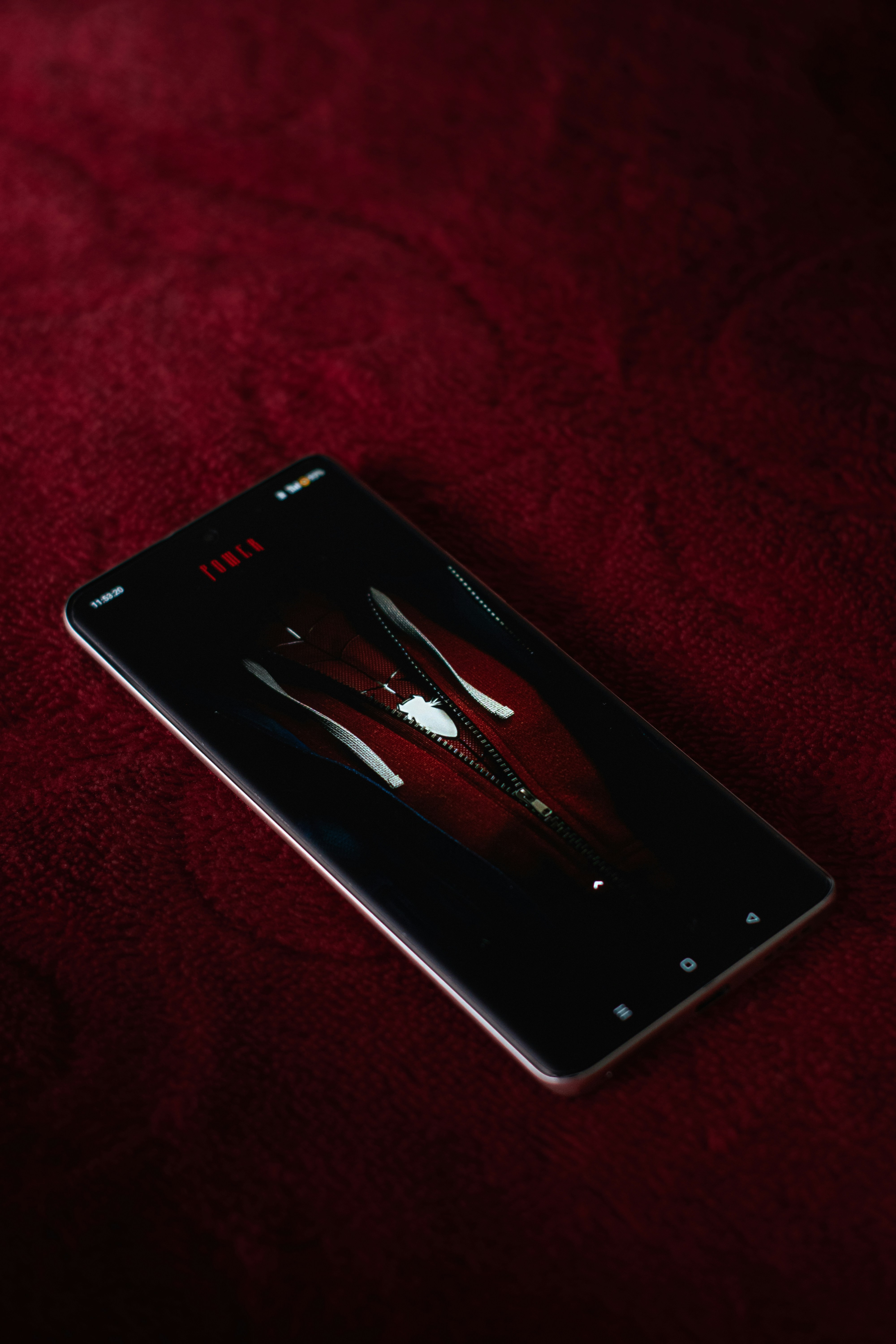 A cell phone sitting on top of a red surface