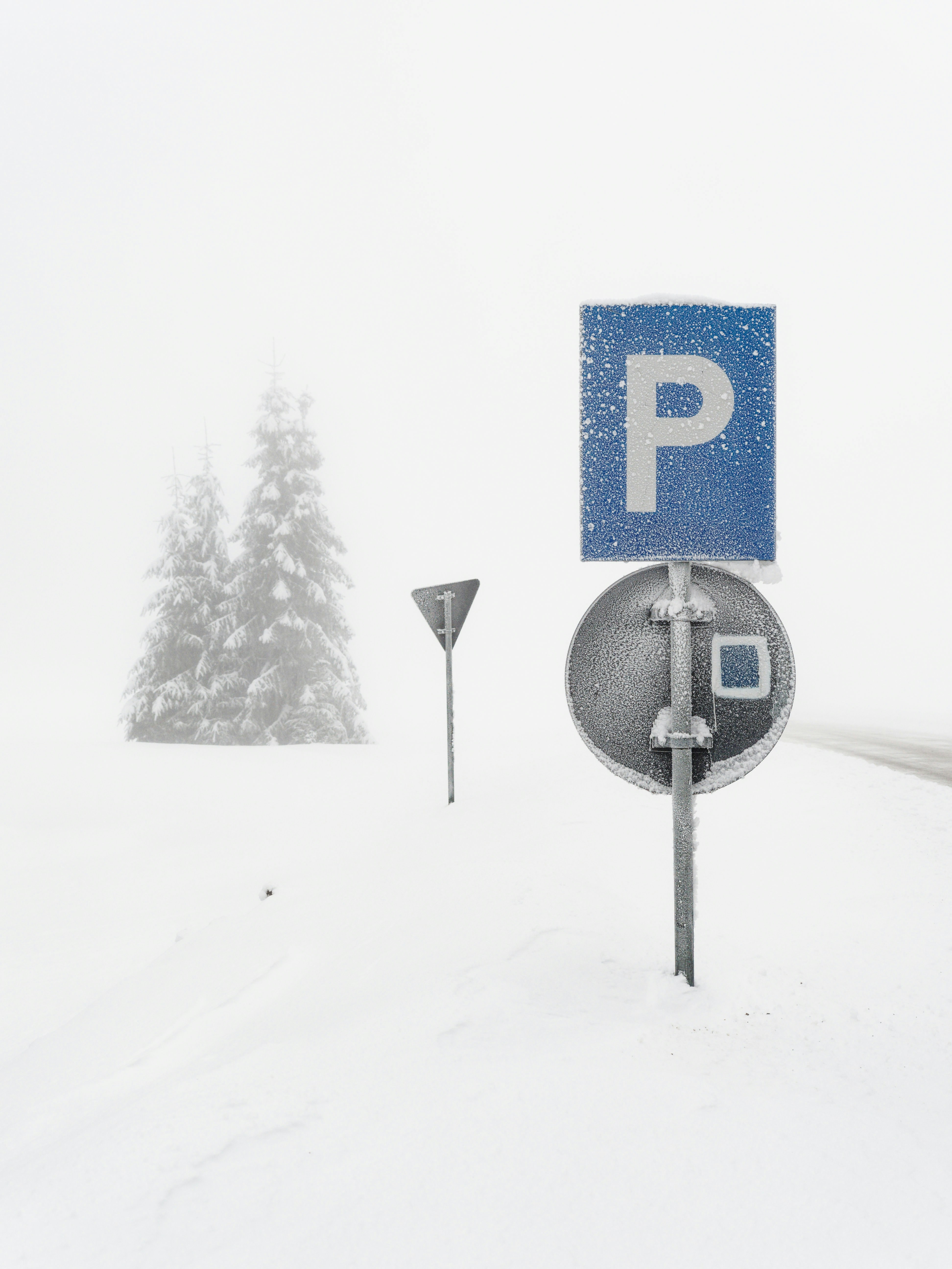 A parking sign on a pole in the snow photo – Free Road signs in the ...