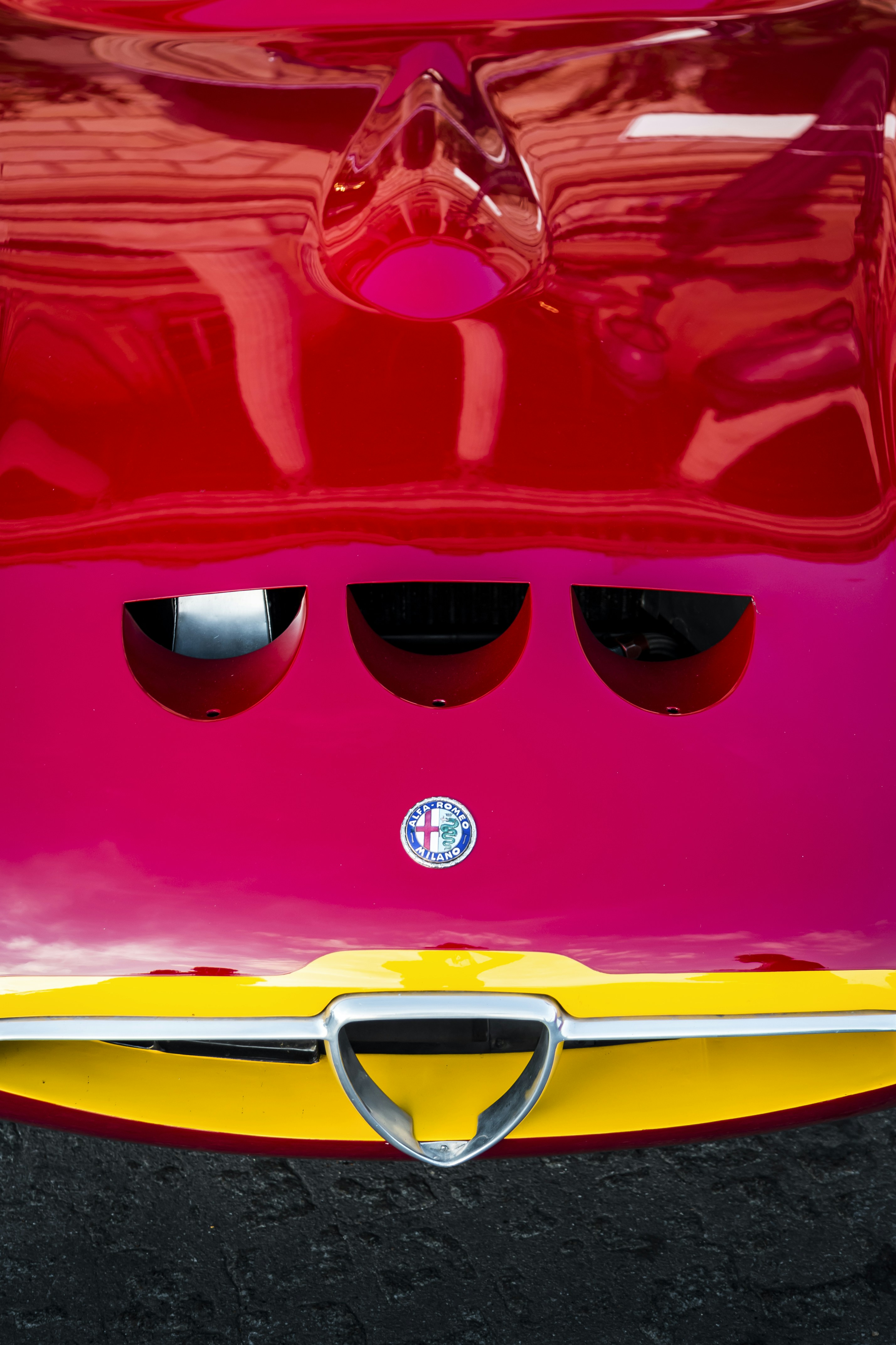 Crimson Contours: Alfa Romeo Emblem Framed by Glossy Hood Reflections