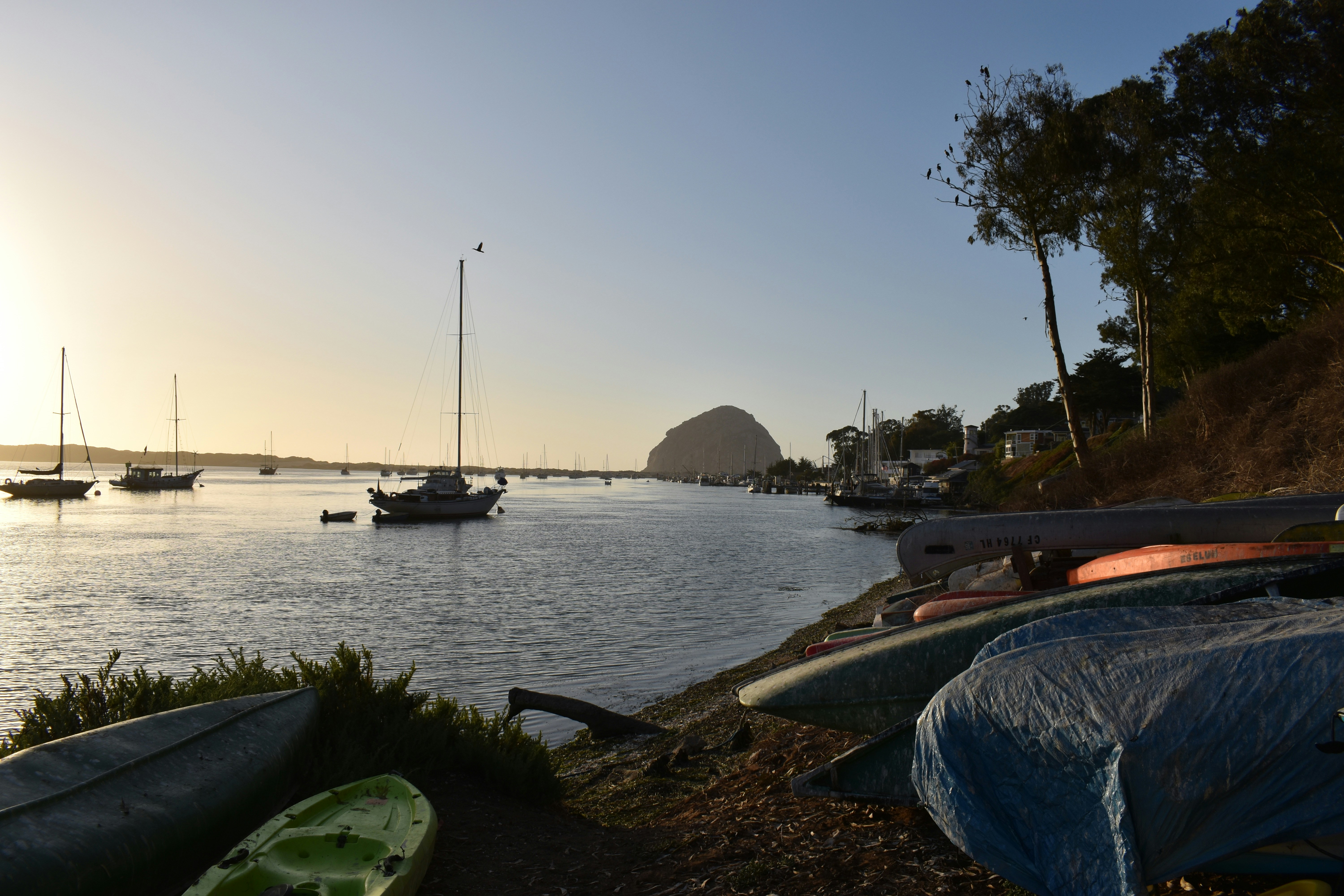 Distant Rock at Sunset: Boats, Kayaks, and a Calm Harbor