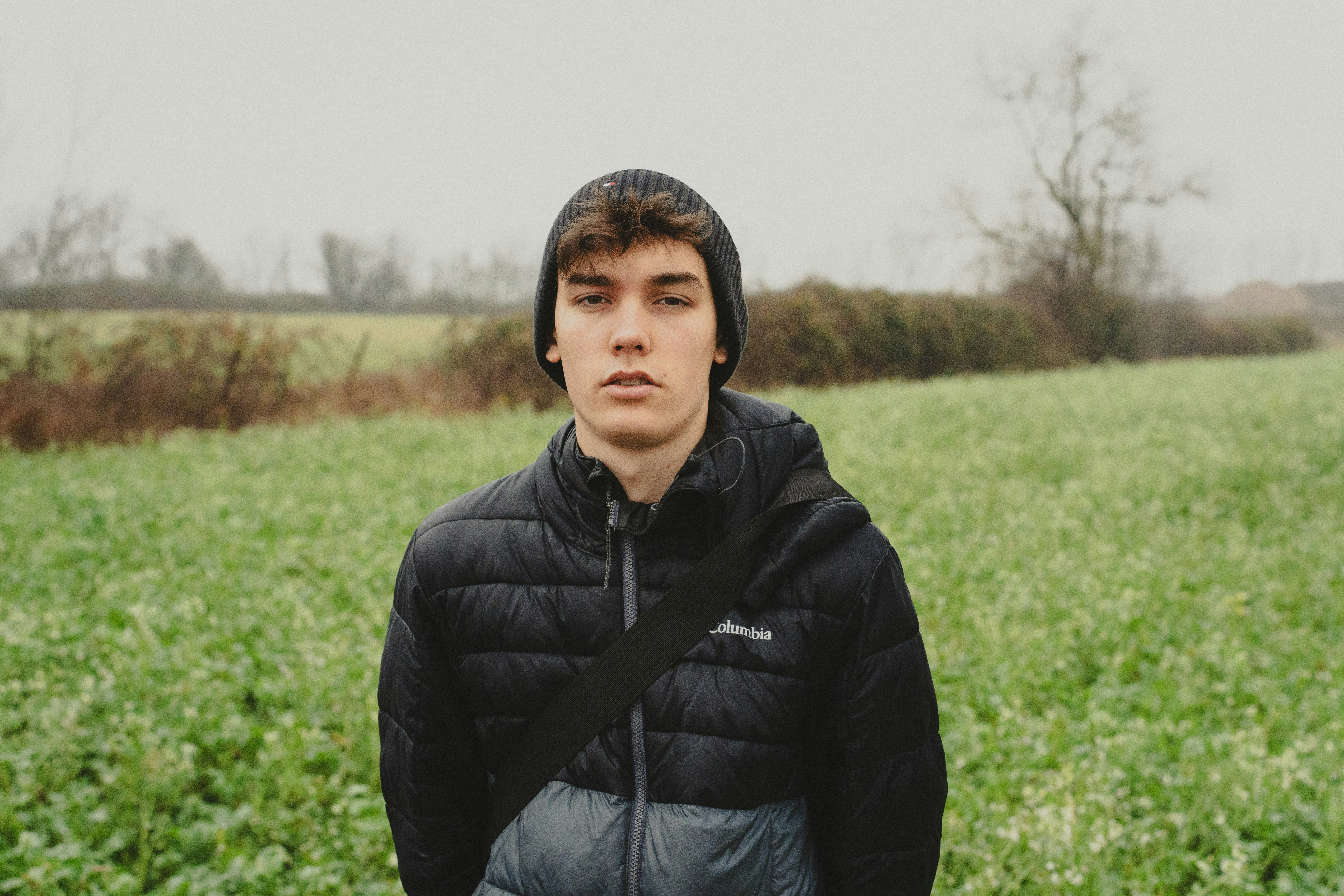 Verdant Stillness: Portrait of a Young Man in an Overcast Field