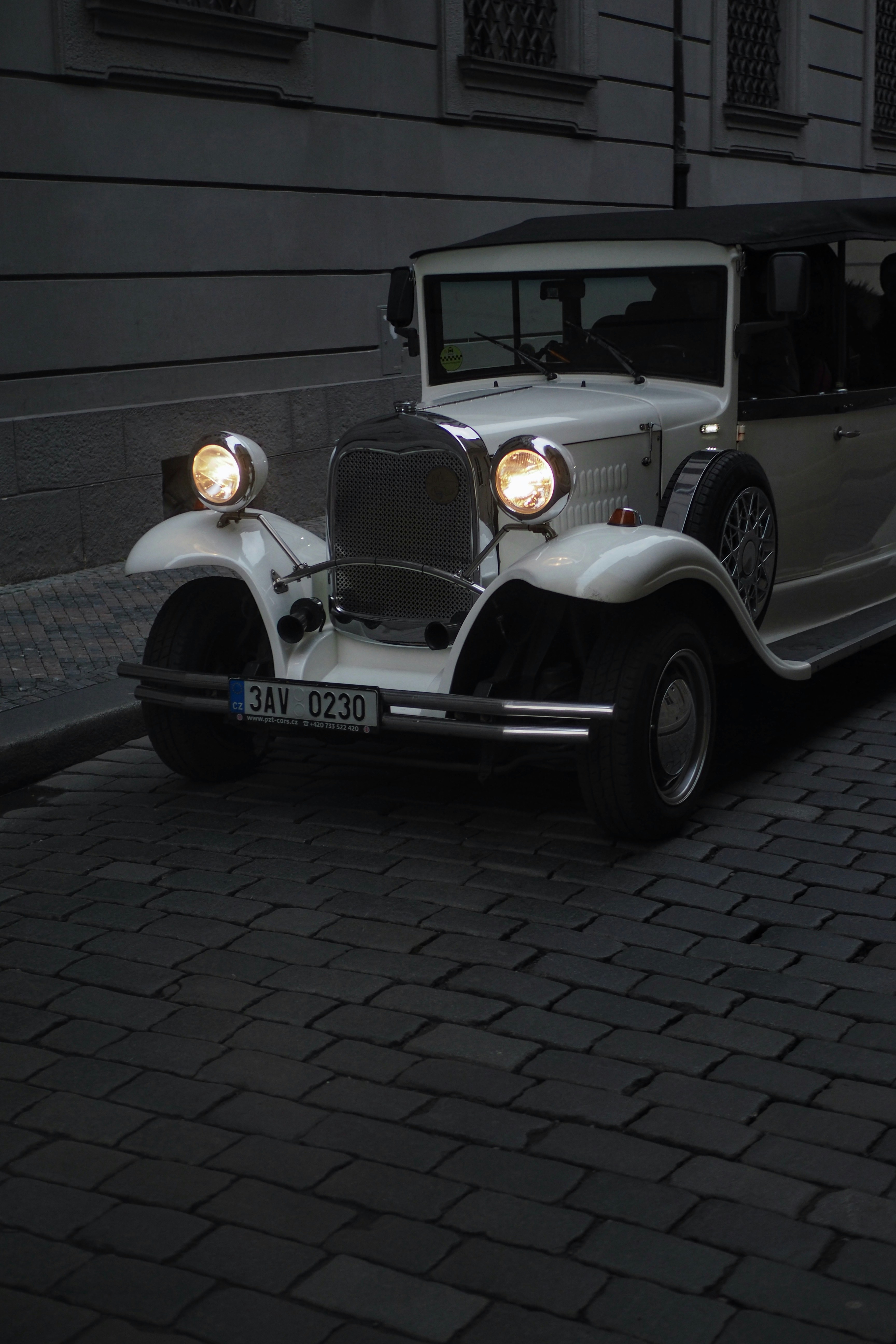Chrome on Cobblestones: A Vintage Touring Car at Dusk
