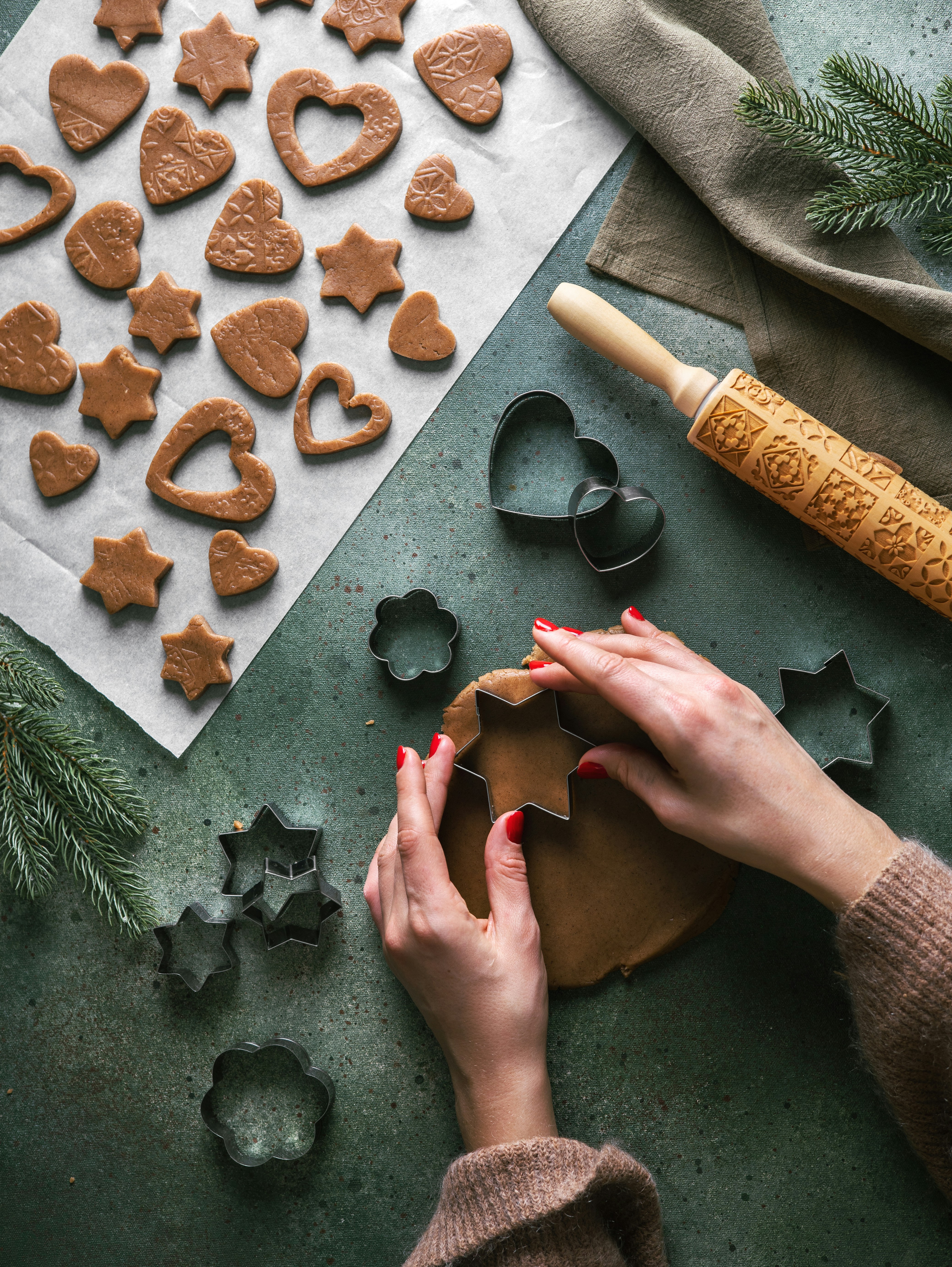 A woman is decorating cookies with cookie cutters photo – Free Woman ...