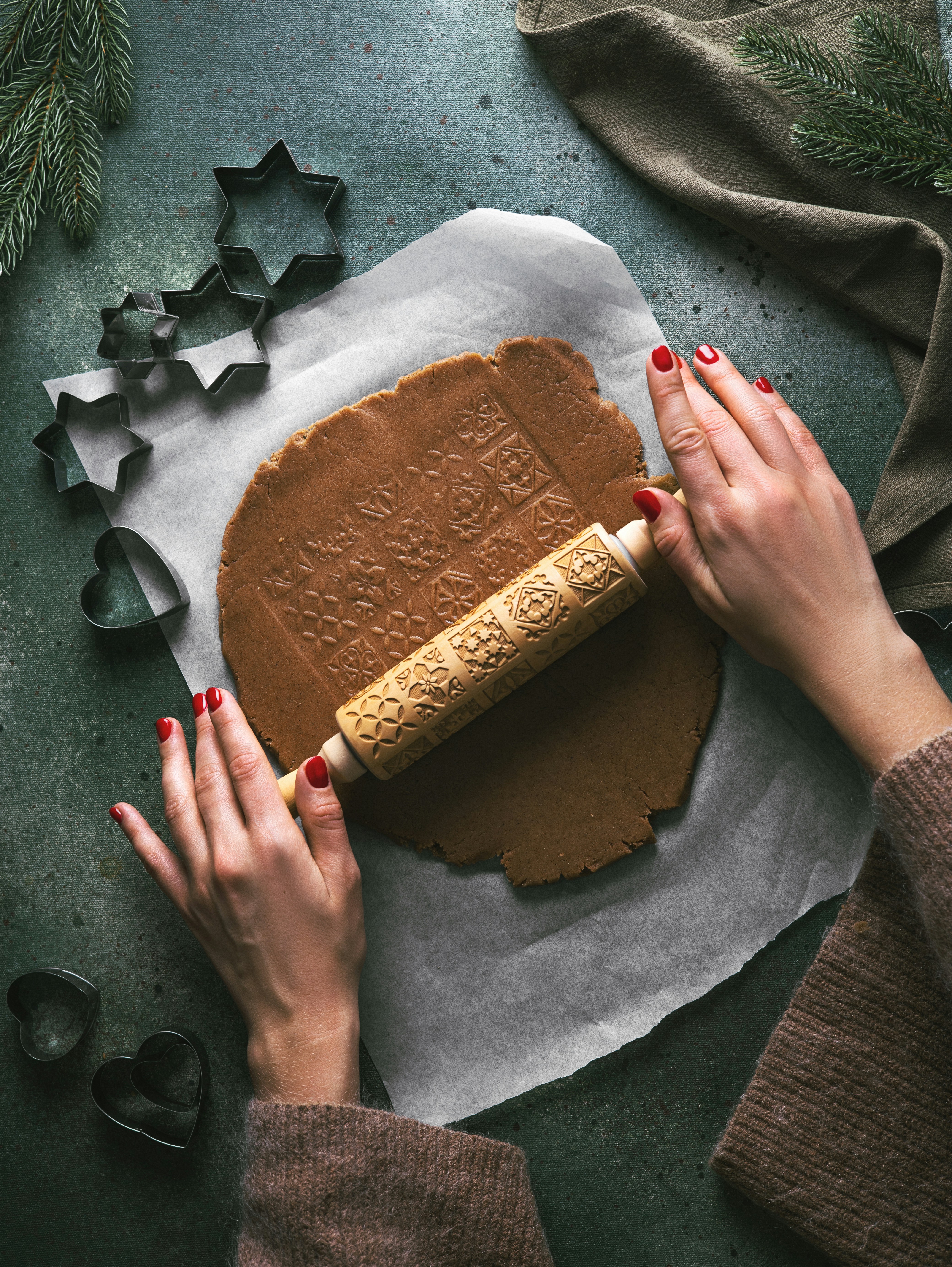 A woman rolling out a cookie on top of a table photo – Free Food and ...