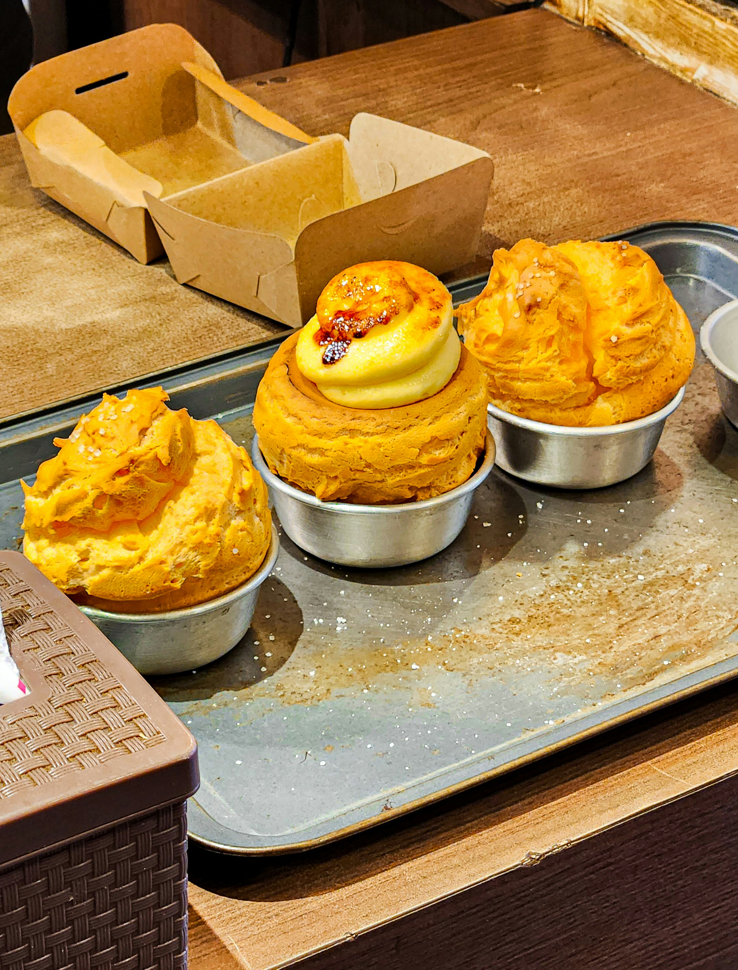 Cream Puff Crown: A Trio of Golden Pastries on a Warm Bakery Tray