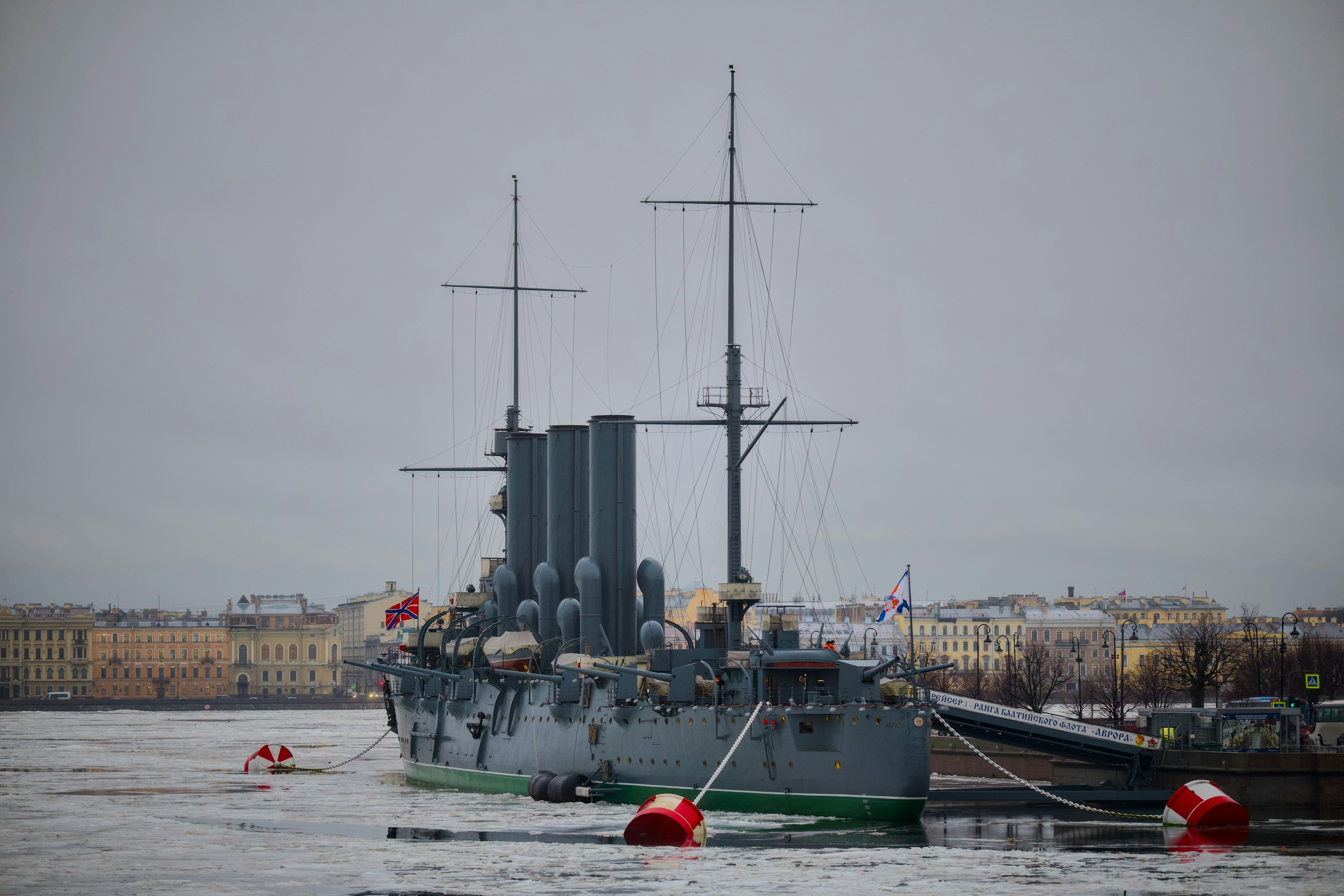 Harbor Guardian: A gray cruiser anchored against a quiet city silhouette