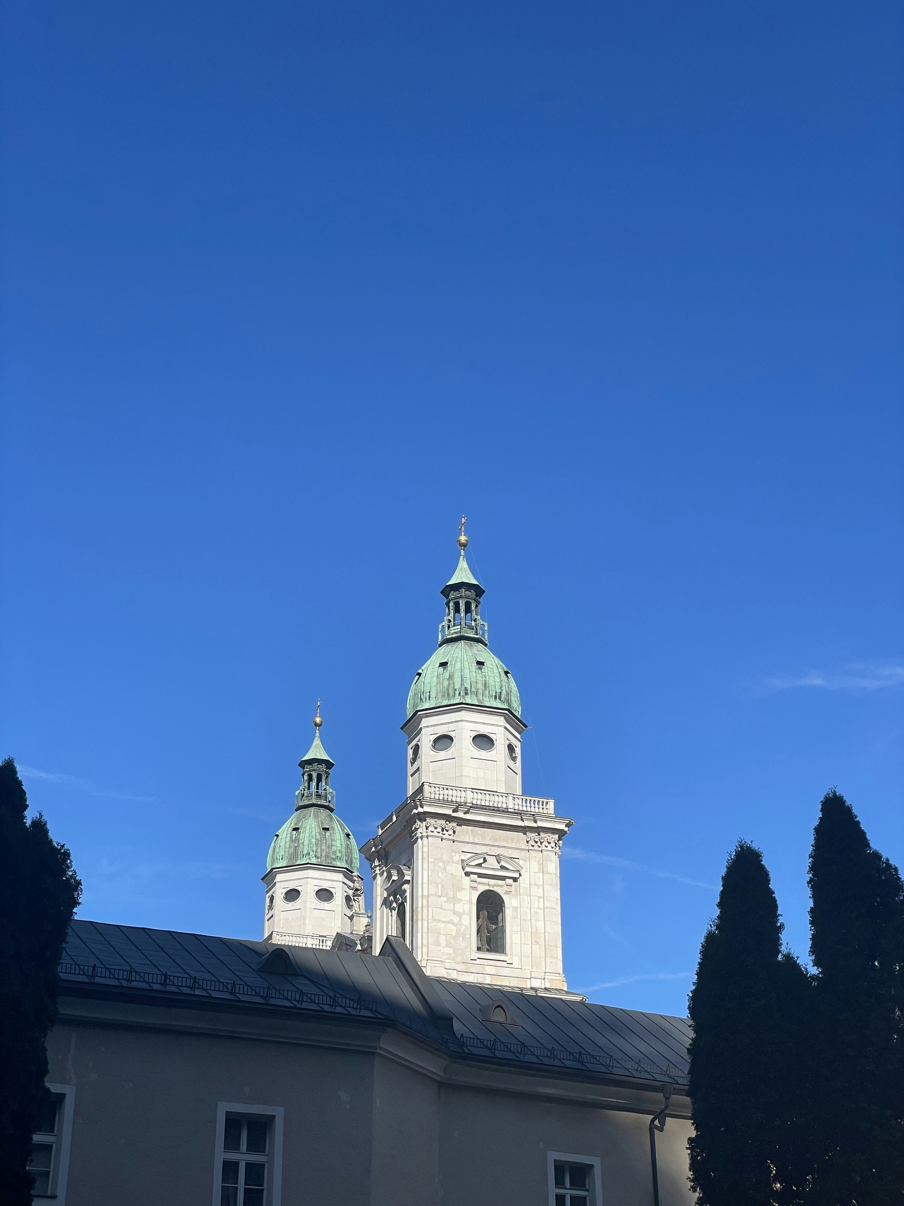 Verdigris Domes Against a Cerulean Sky: Neoclassical Towers Reaching Above the Roofline