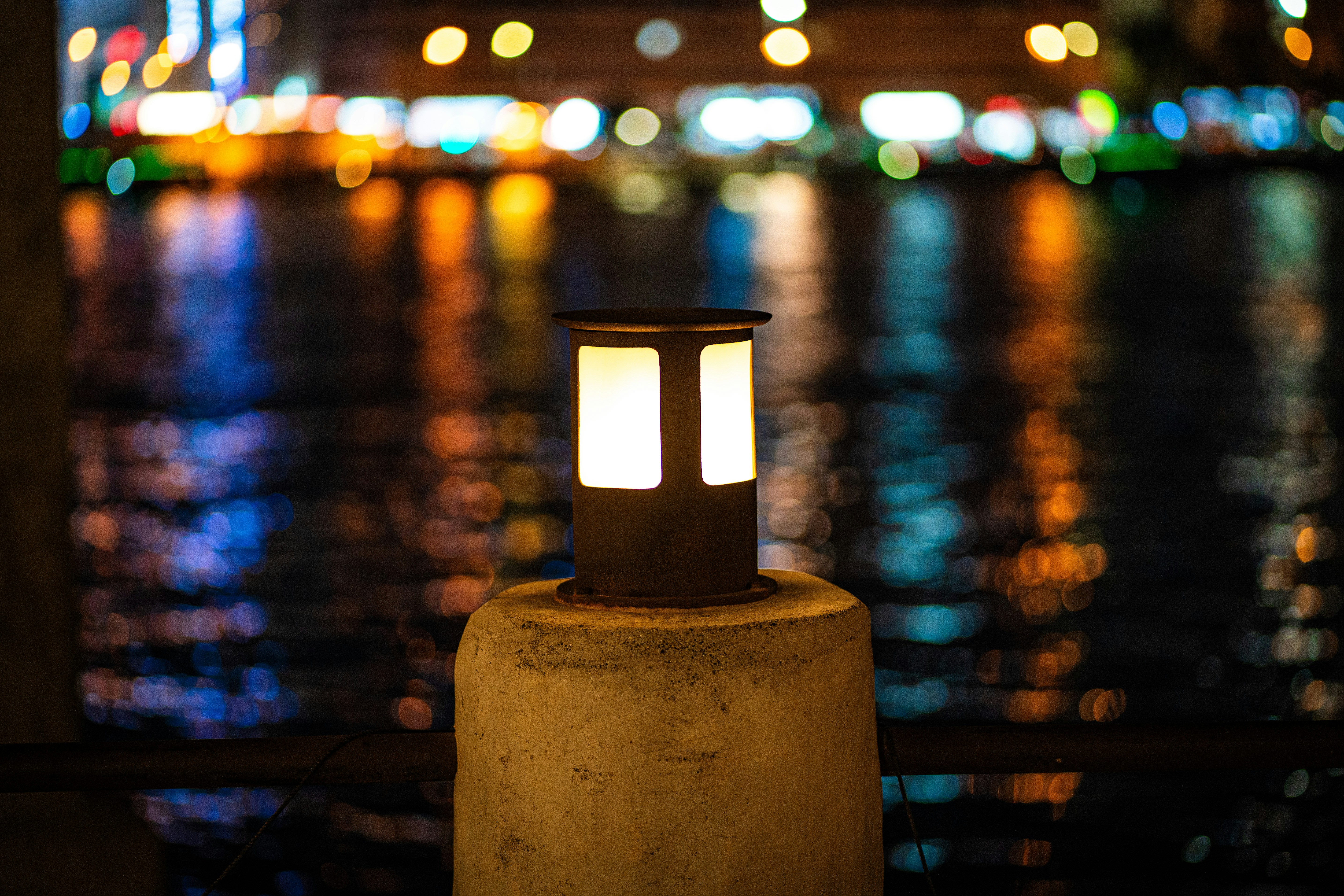 Midnight Lantern on the Waterfront: A Quiet Beacon Amid Neon Ripples