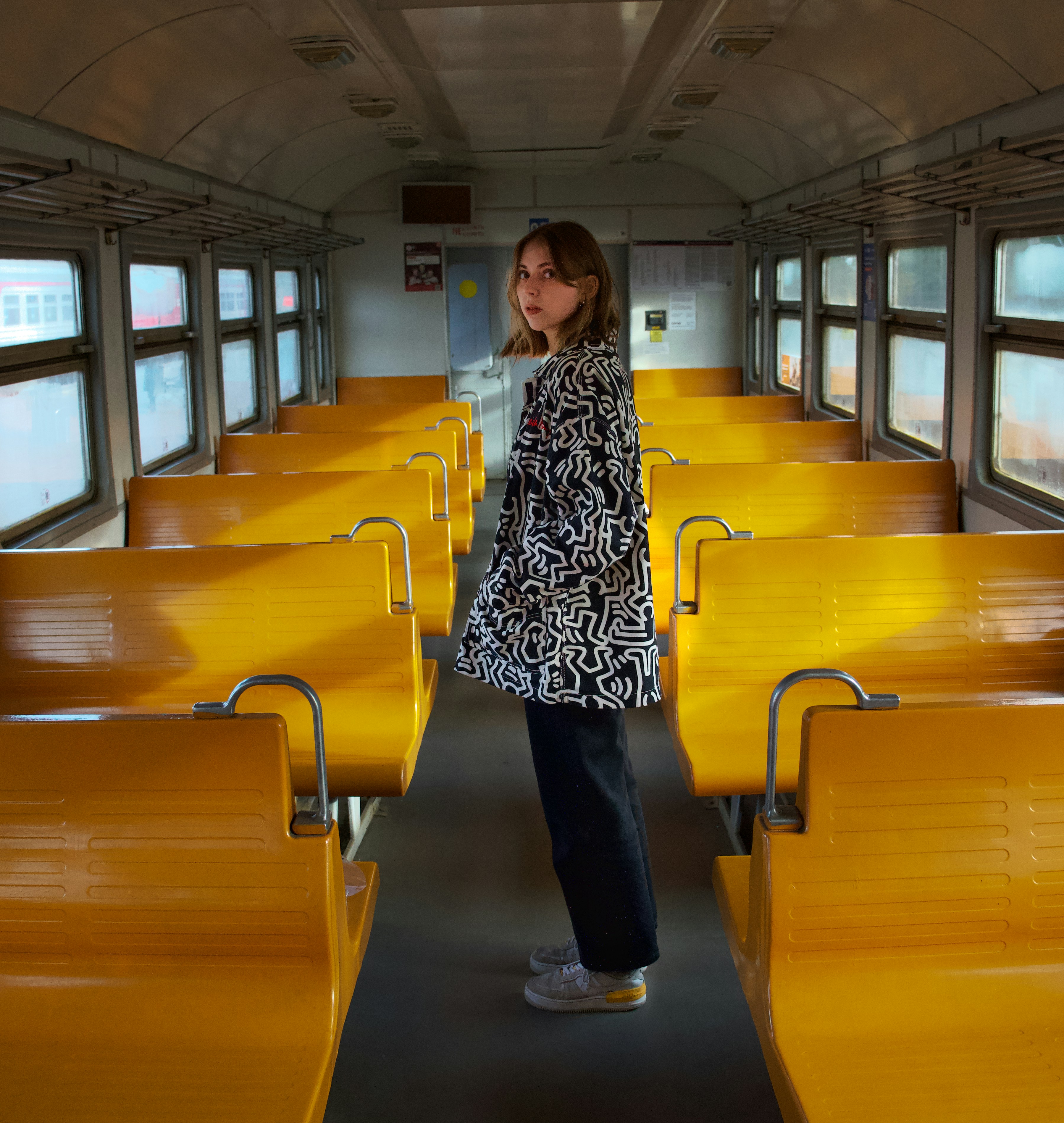 On the Move: A Quiet Portrait in a Neon-Orange Train Car