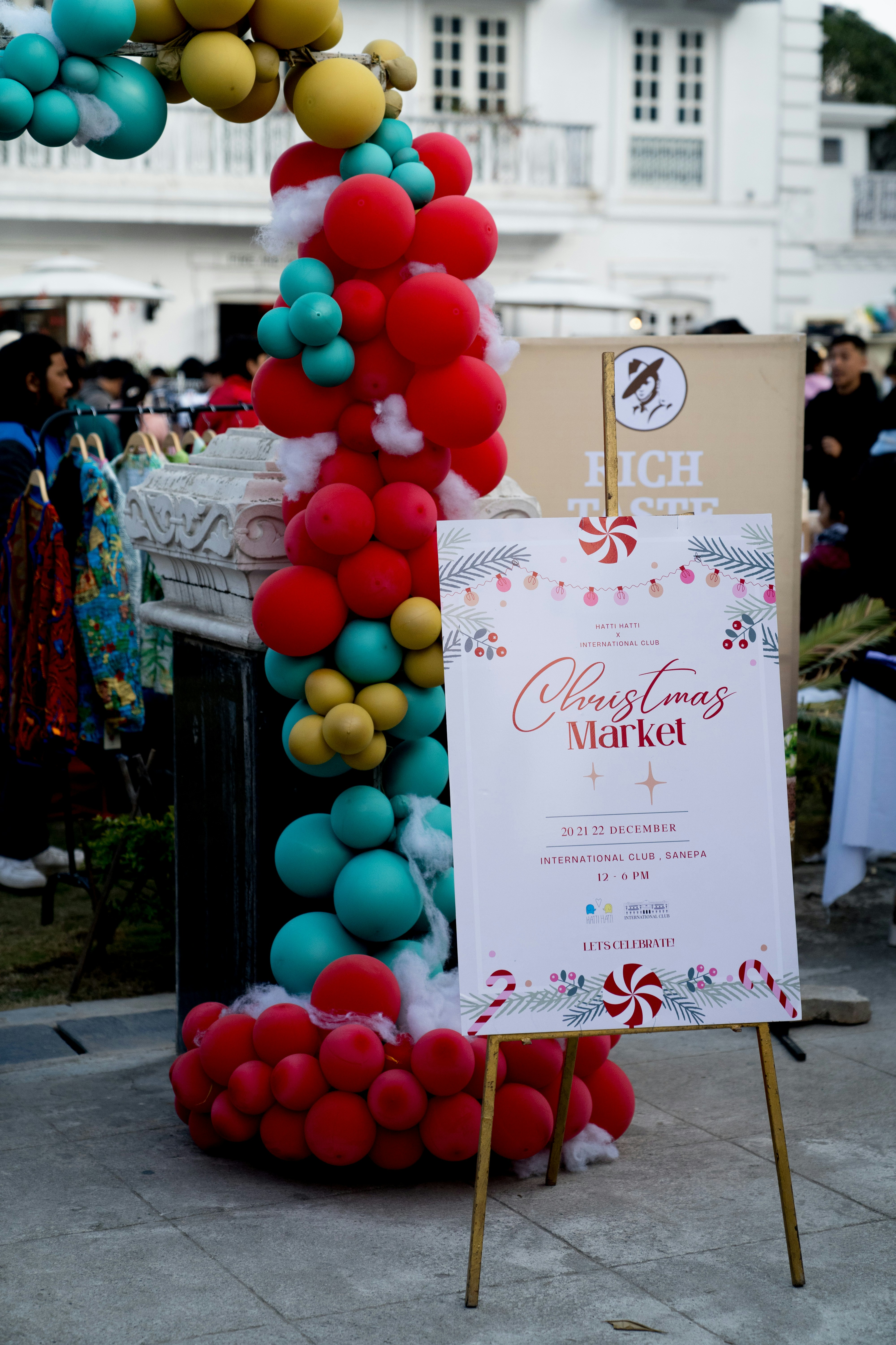 Candy-Colored Archway and Christmas Market Poster at a Busy Street Fair