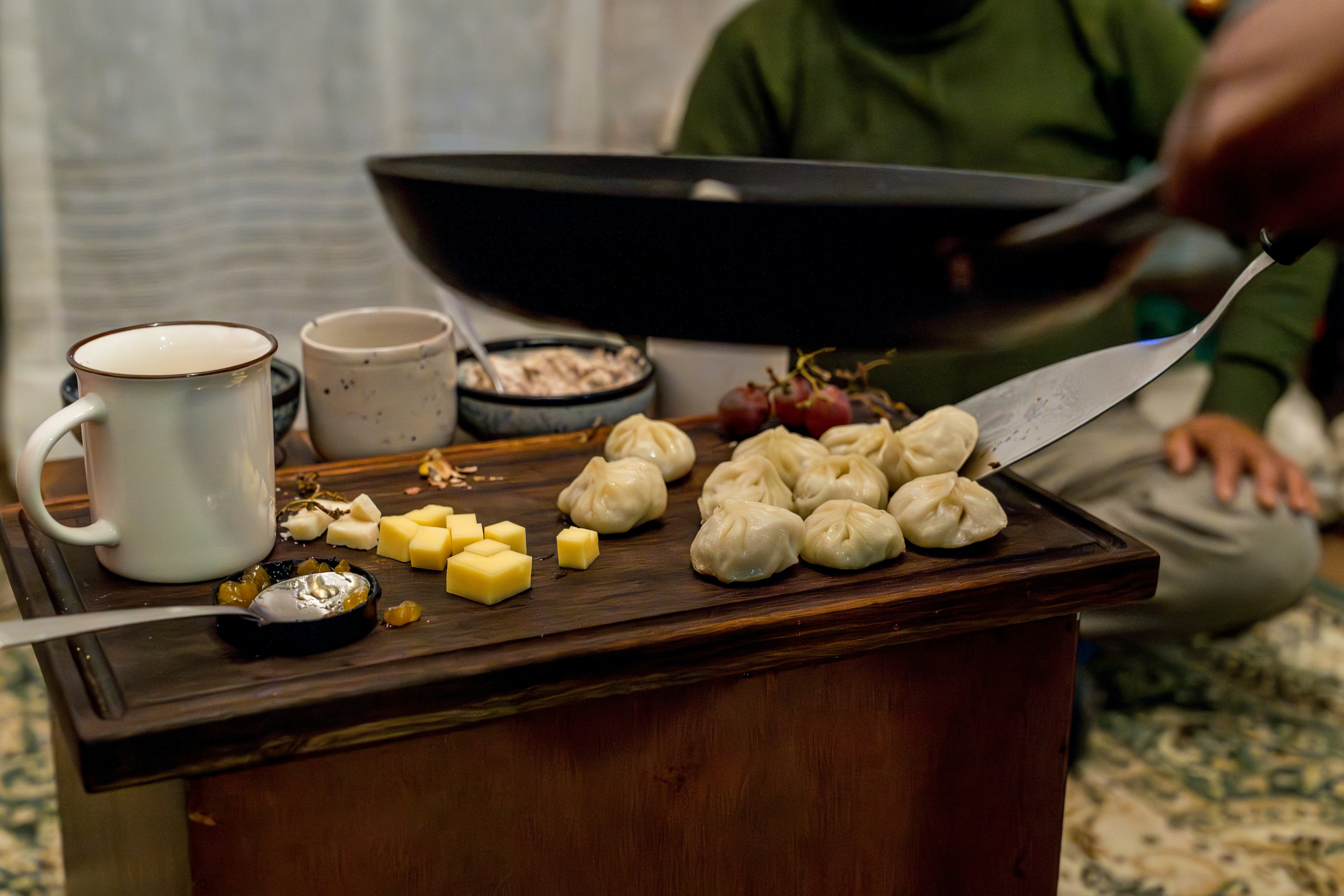 Mid-Table Feast: Dumplings and Cheese on a Dark Wood Board