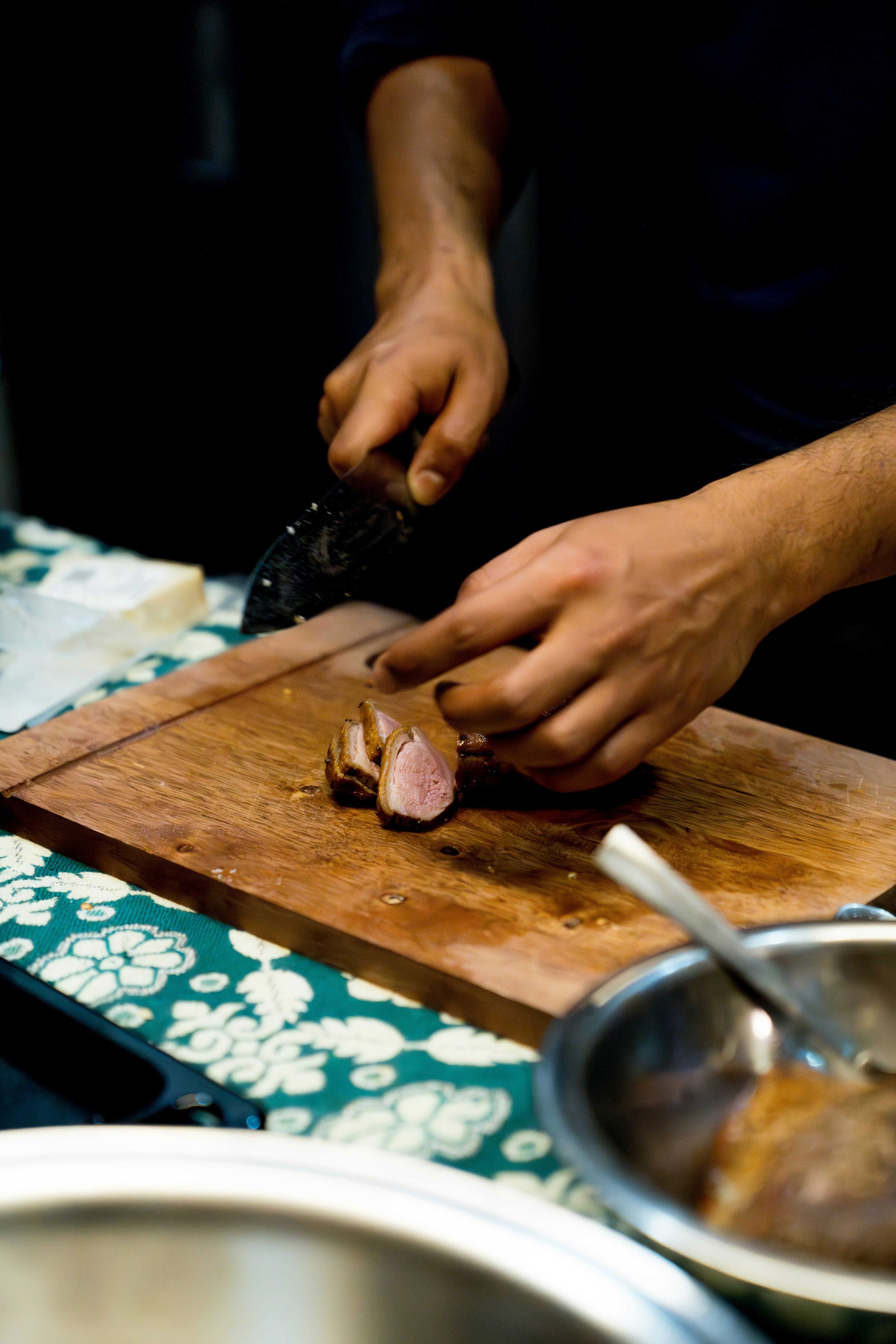 Edge of Precision: Slicing a Pink-Centered Roast on a Wooden Board