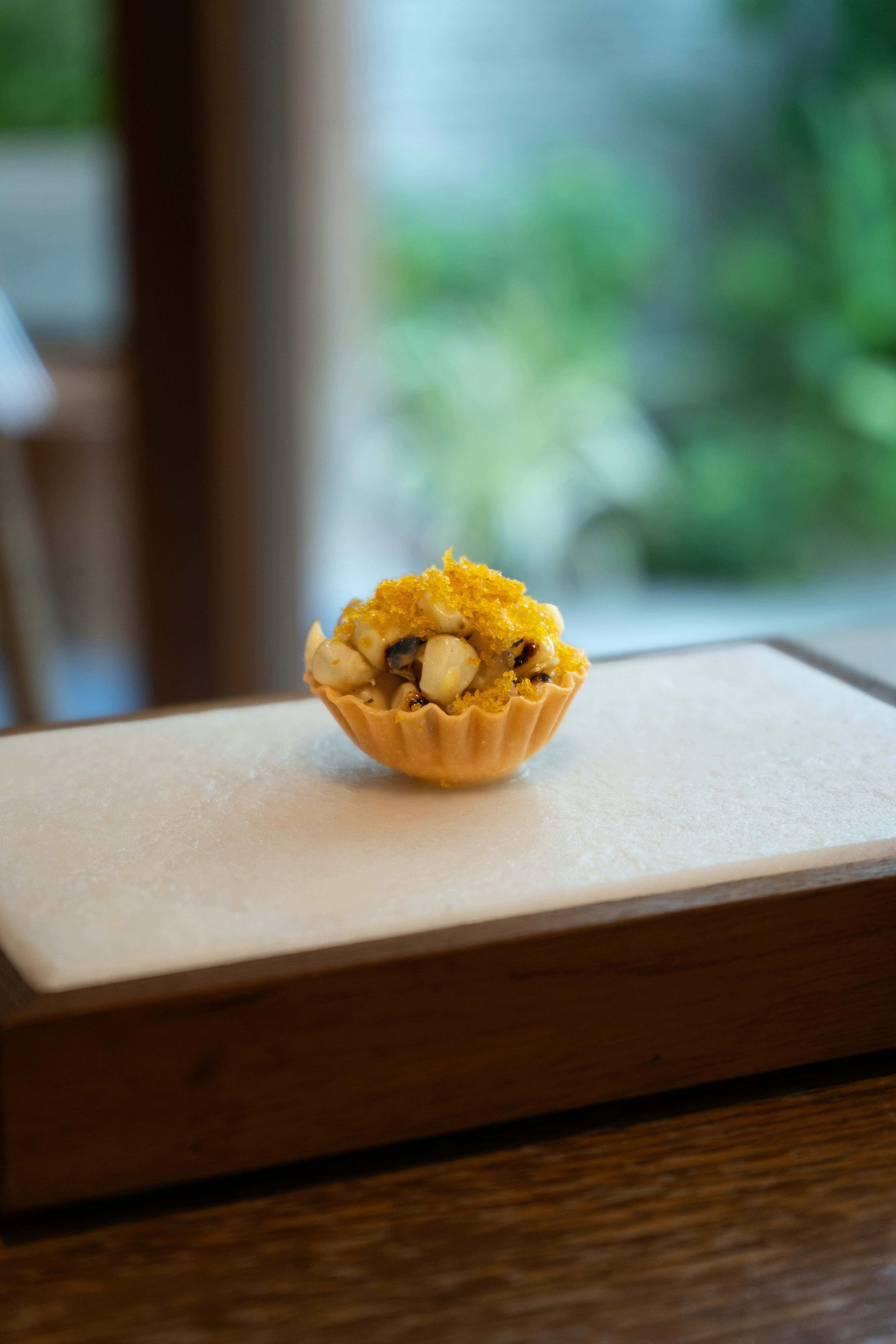 Golden-topped tartlet on a wood-topped stage