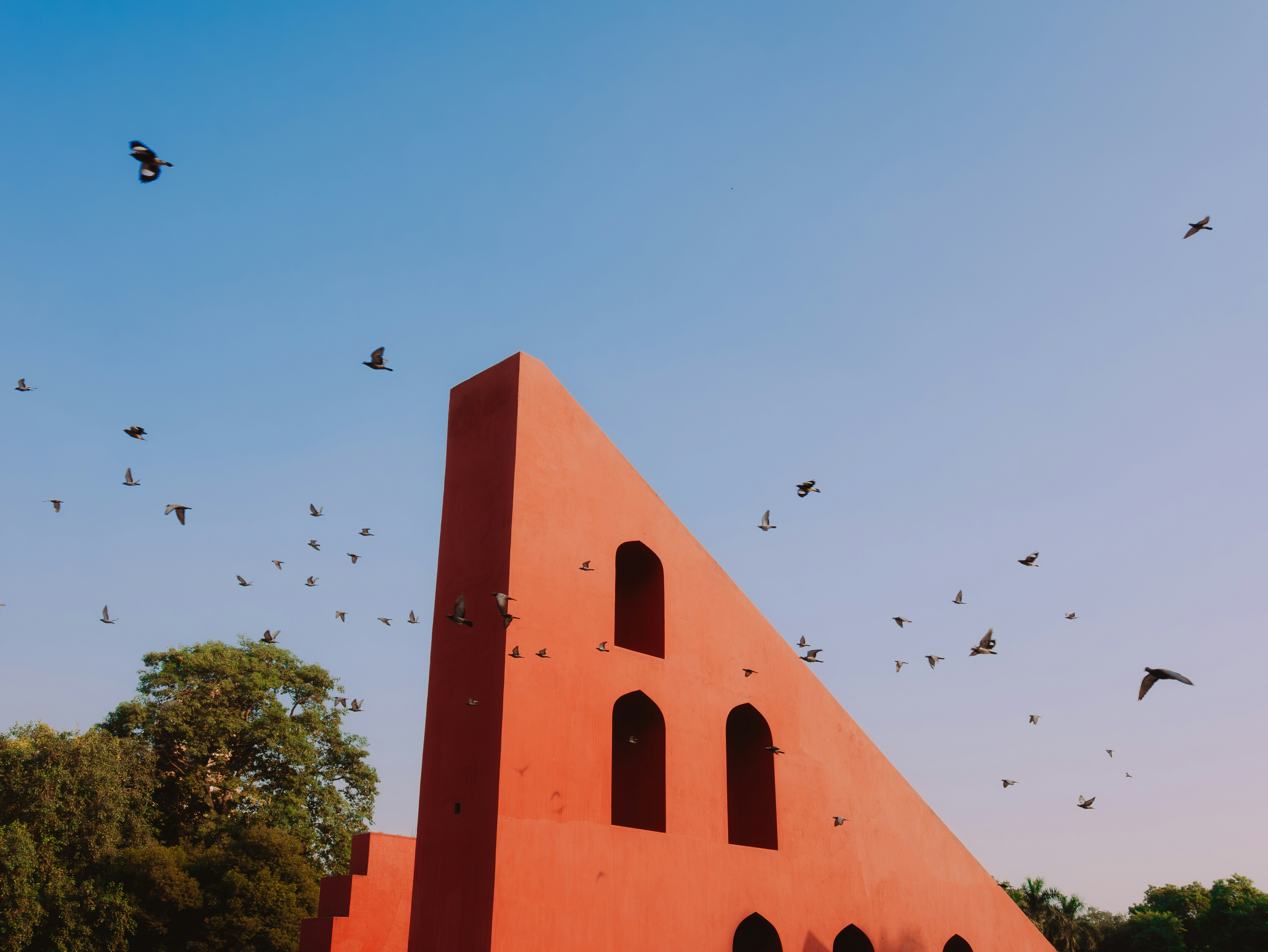 Terracotta Archway Against a Skyful of Birds
