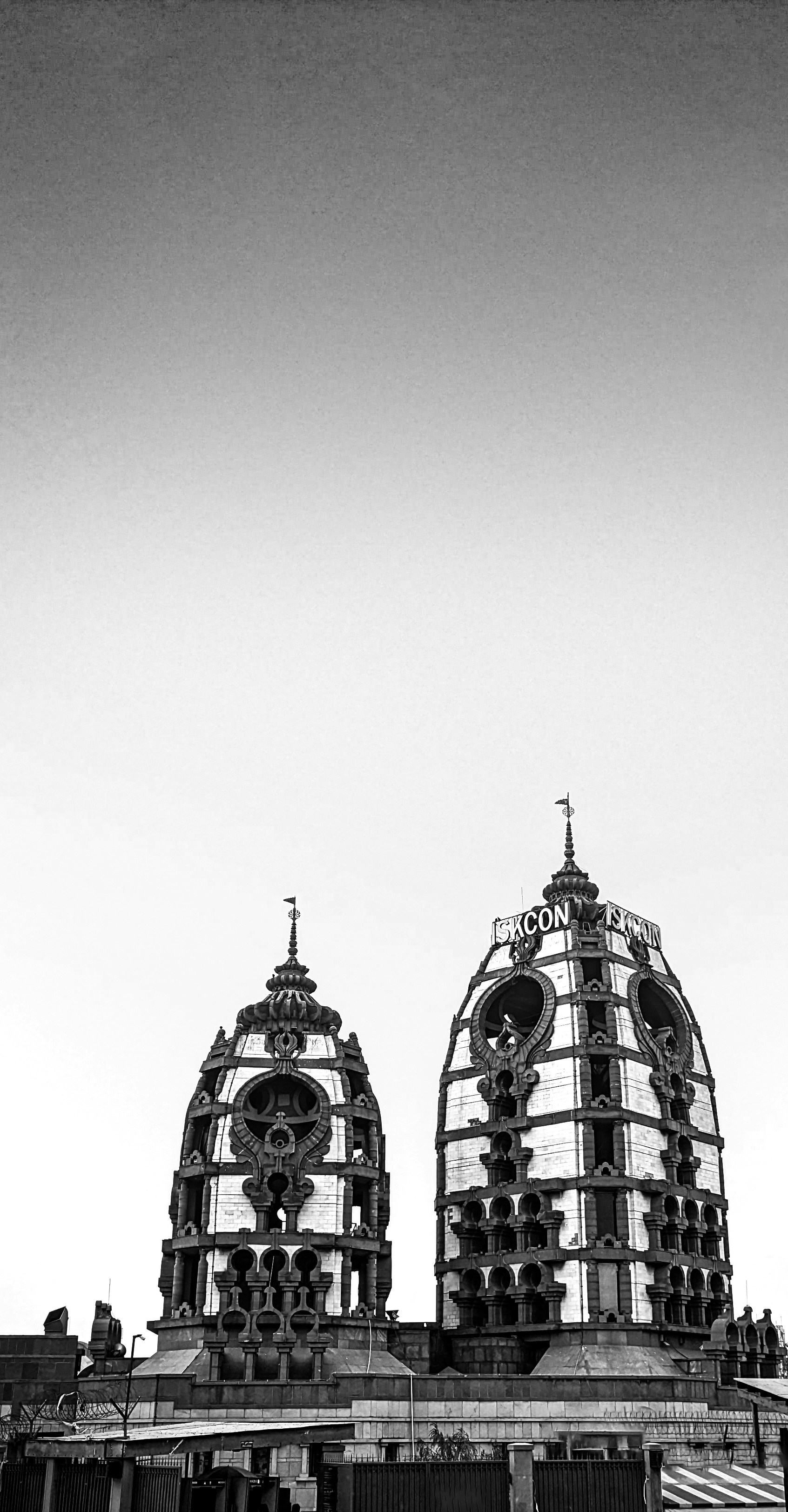 Monochrome view of two intricately designed temple towers under a clear sky.