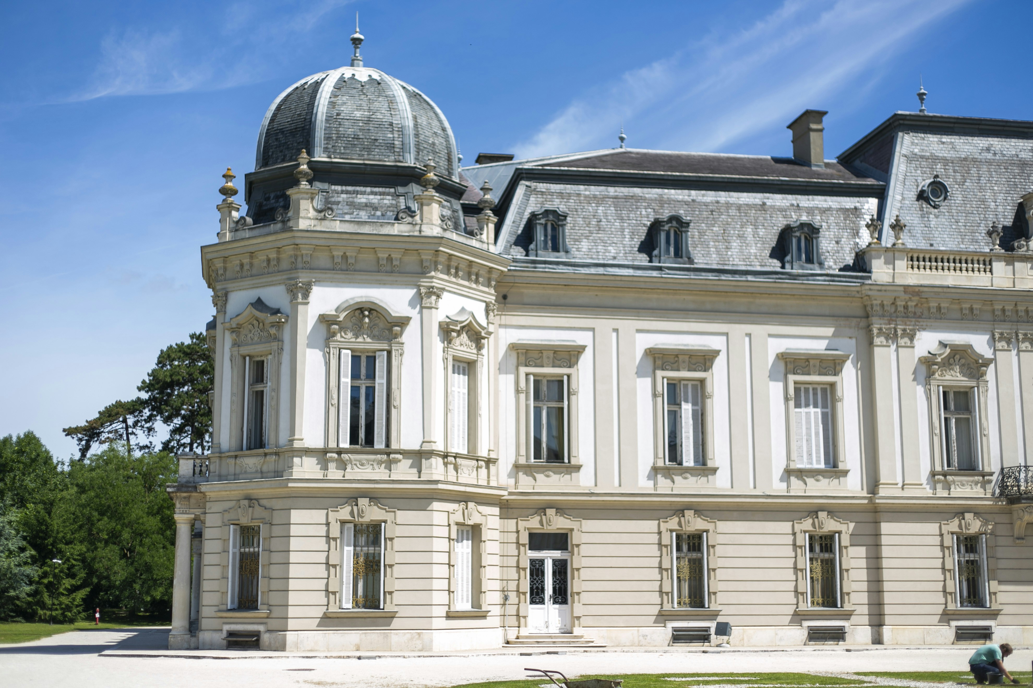 Neoclassical building with ornate details and a dome under a clear blue sky.