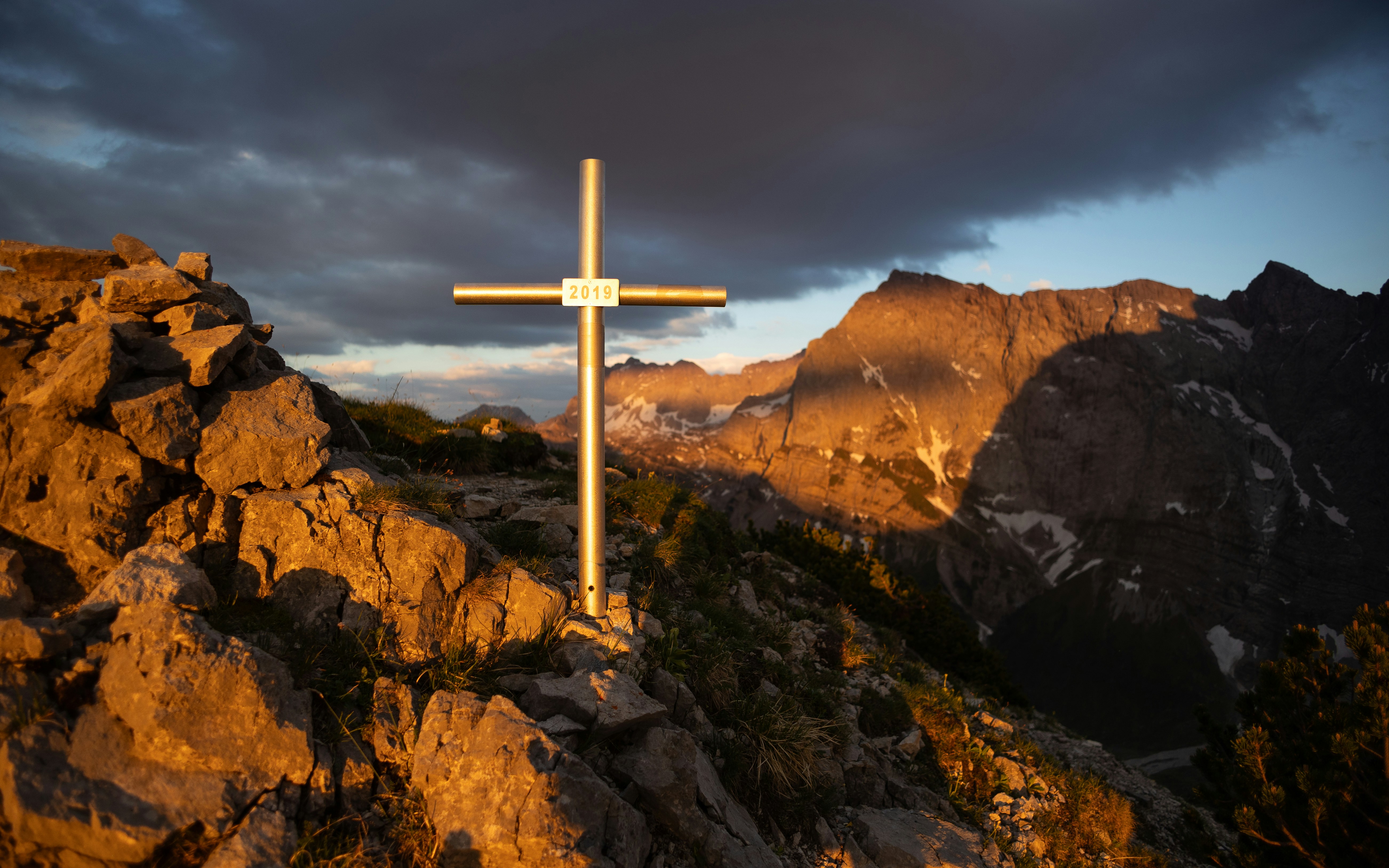 A cross on top of a mountain with mountains in the background photo ...