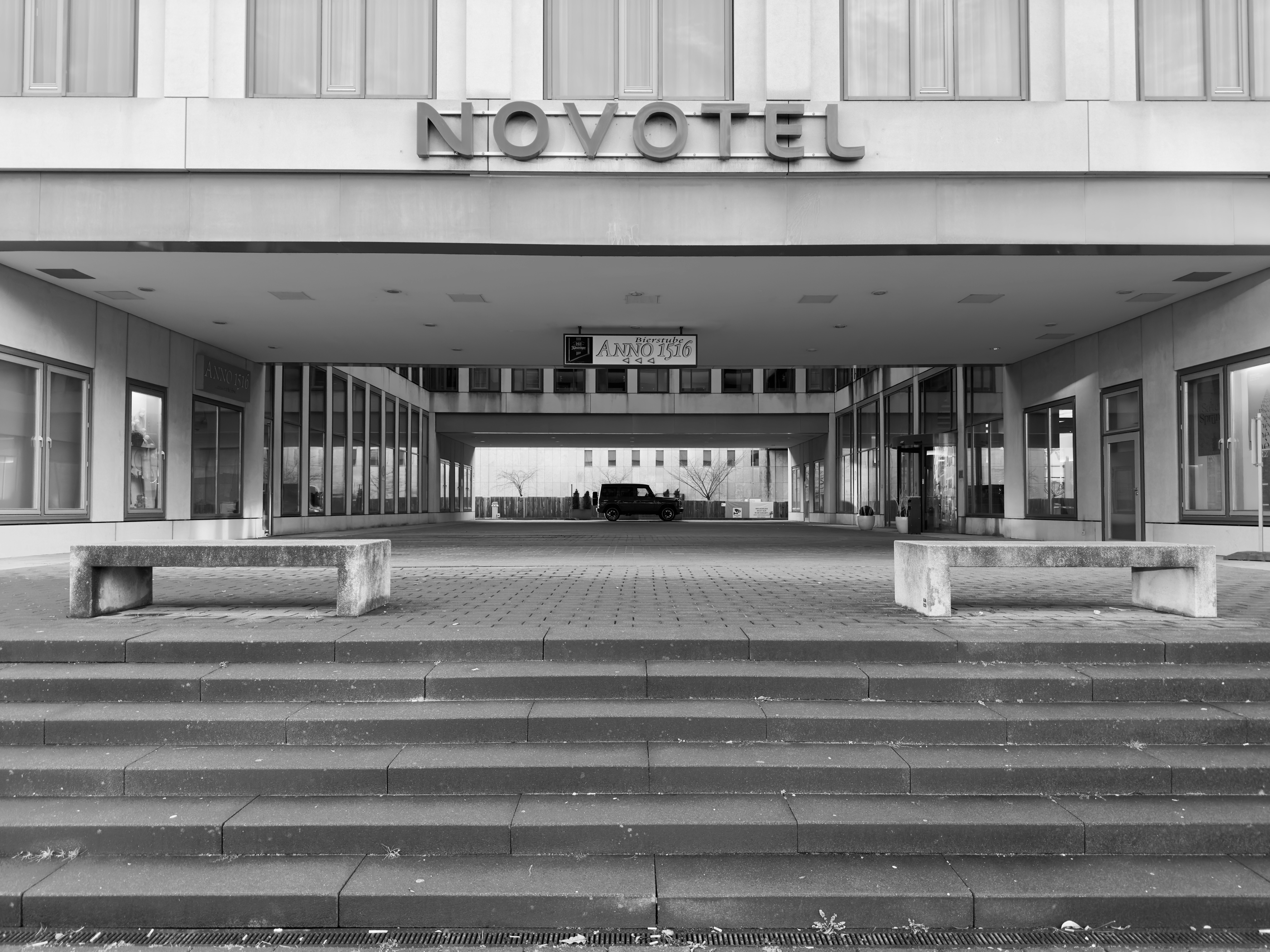 Symmetrical facade of a hotel entrance captured in black and white.
