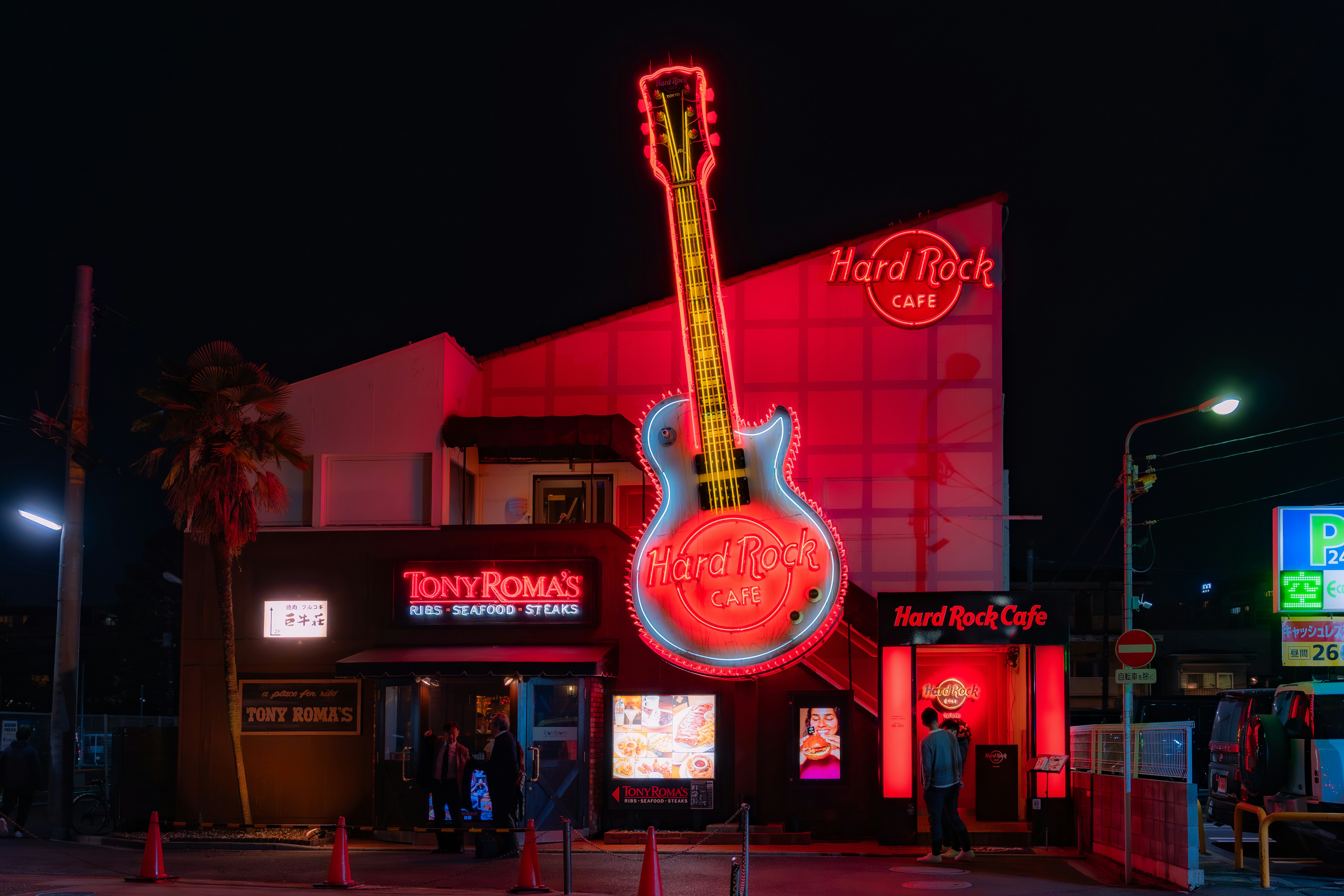 A guitar shaped neon sign in front of a building photo – Free Car Image ...