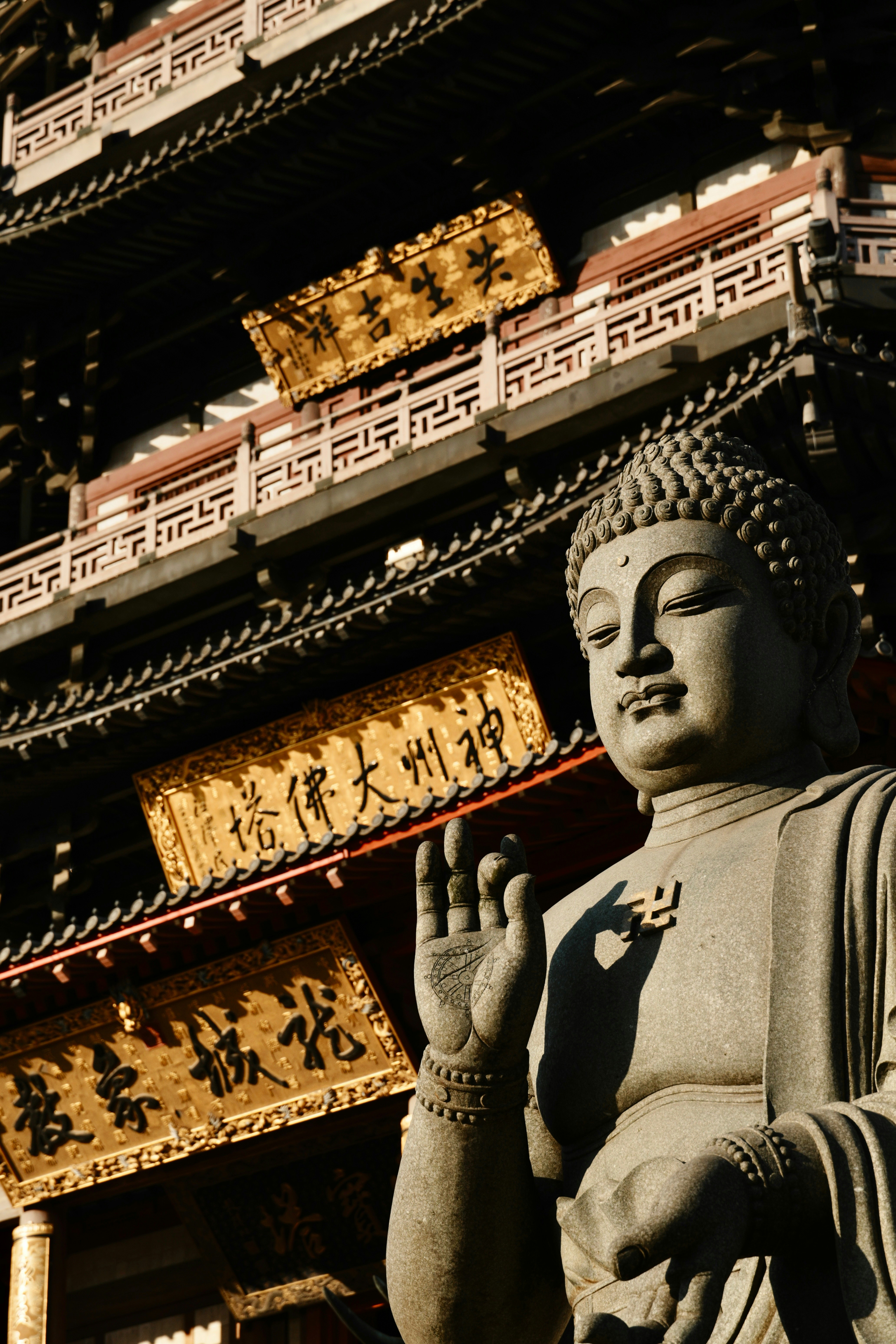 Silent Sentinel Beside Golden Scrolls: Buddha at the Temple Gate