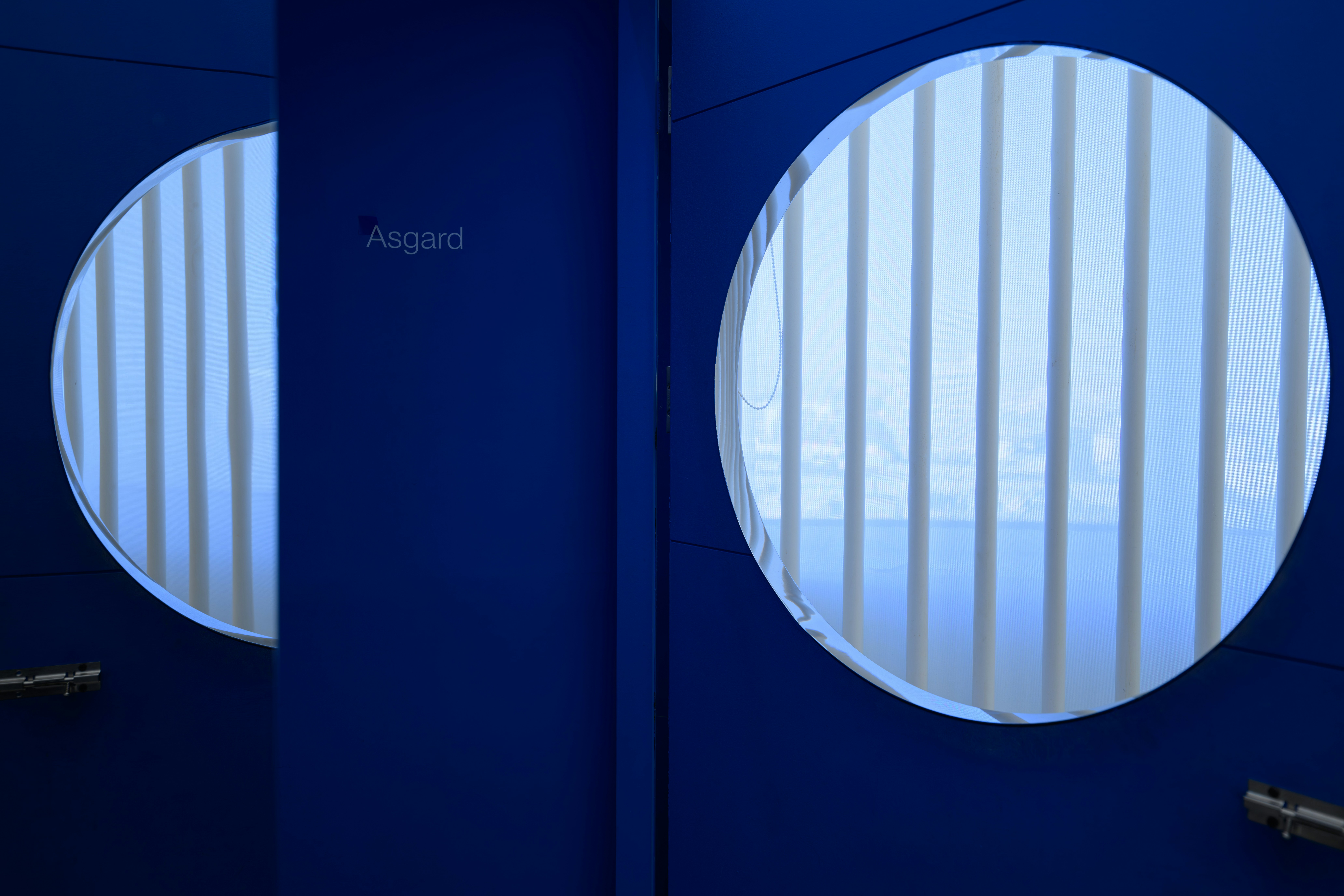 Two blue stalls with round windows and bars on them photo – Free Blue ...