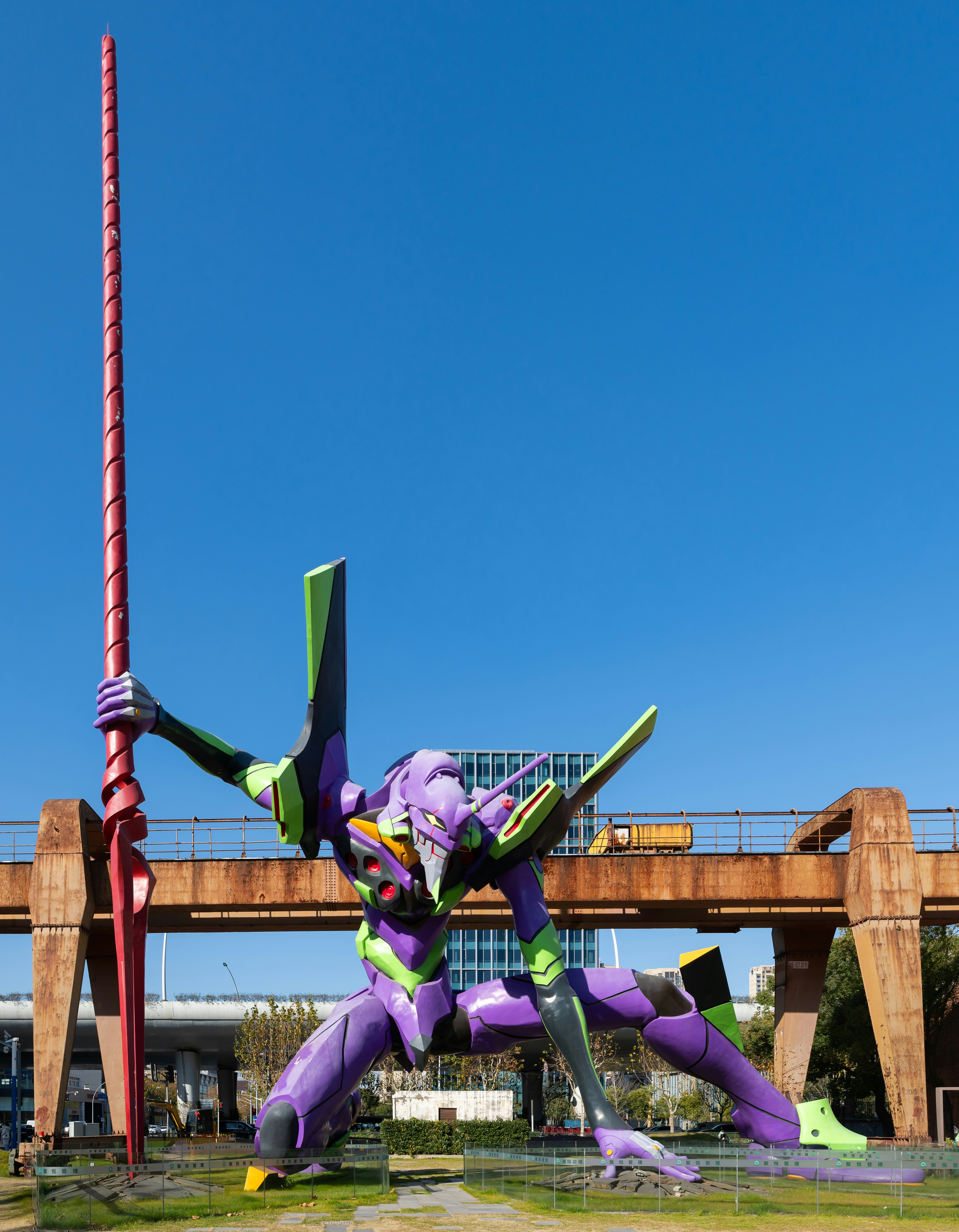 A giant statue of a giant robot is in front of a bridge photo – Free ...