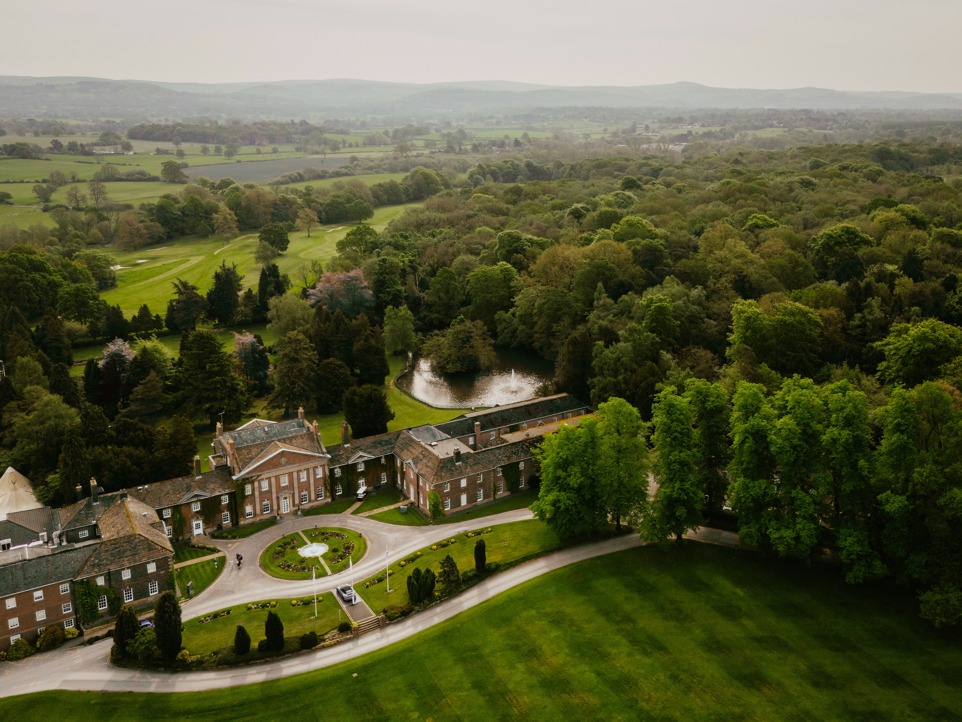 An aerial view of a large building surrounded by trees photo – Free ...