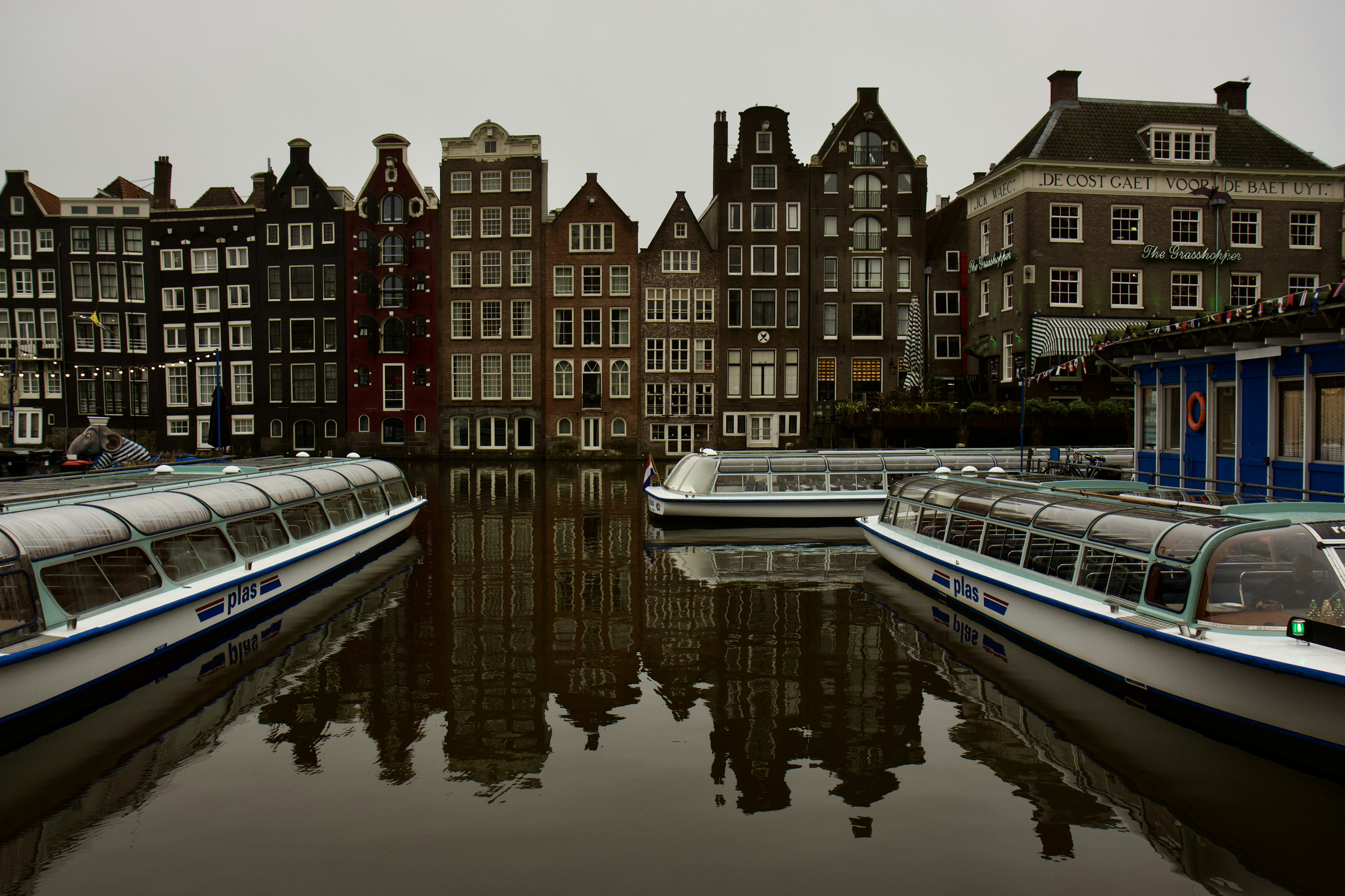 Canalfront Symmetry: Glass-Top Boats Framing Dutch Gables